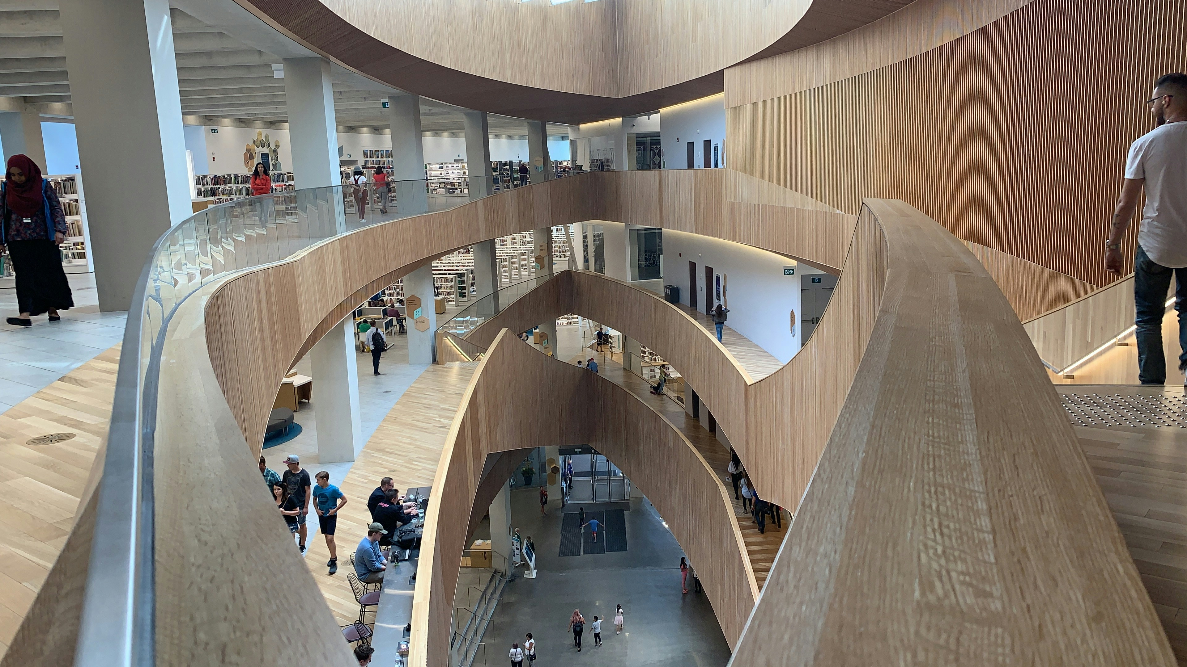 Spiral walkways within a multi-story building featuring wood accents and natural light.