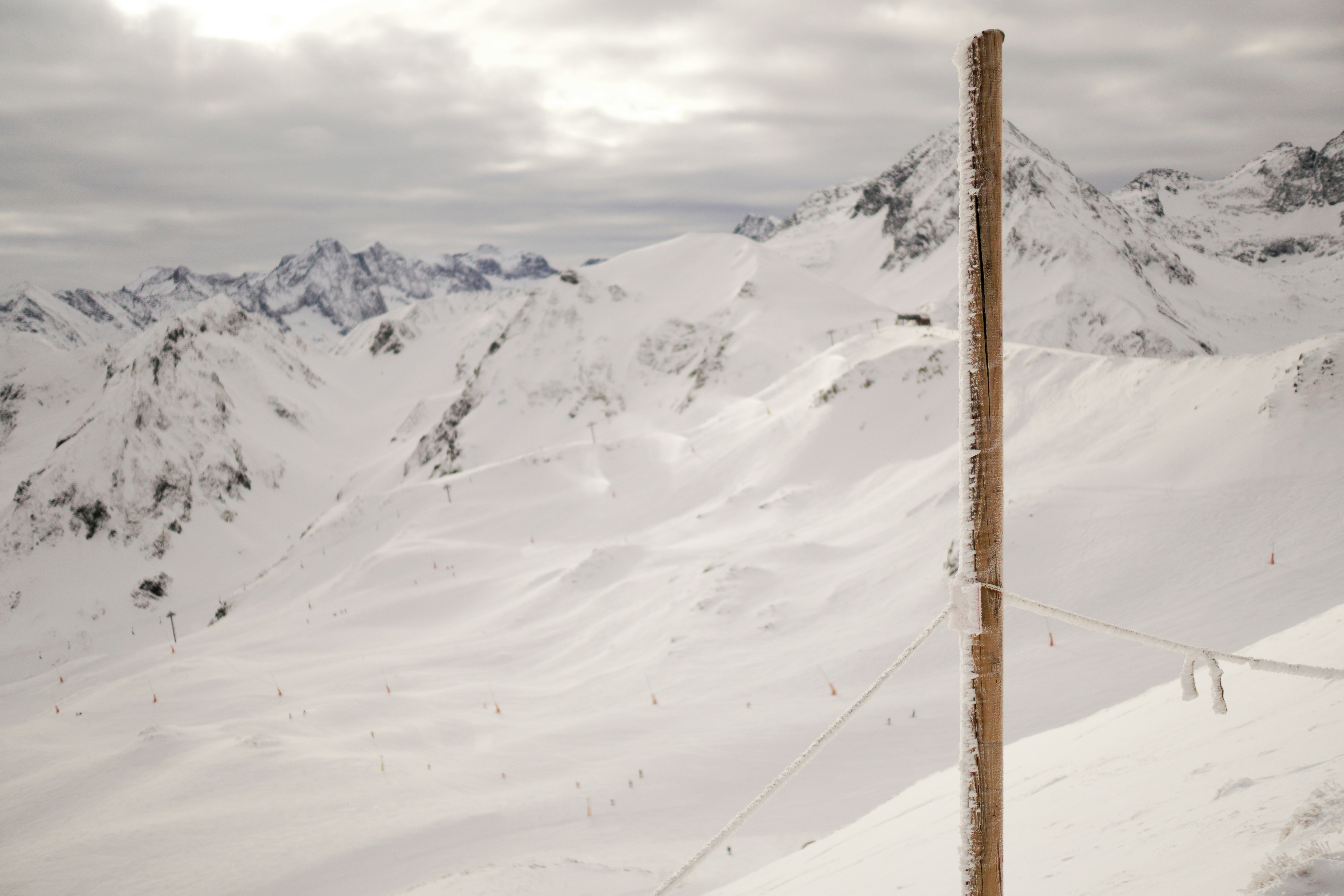 Lone Fence Post Anchored in a Quiet Alpine Sea of Snow