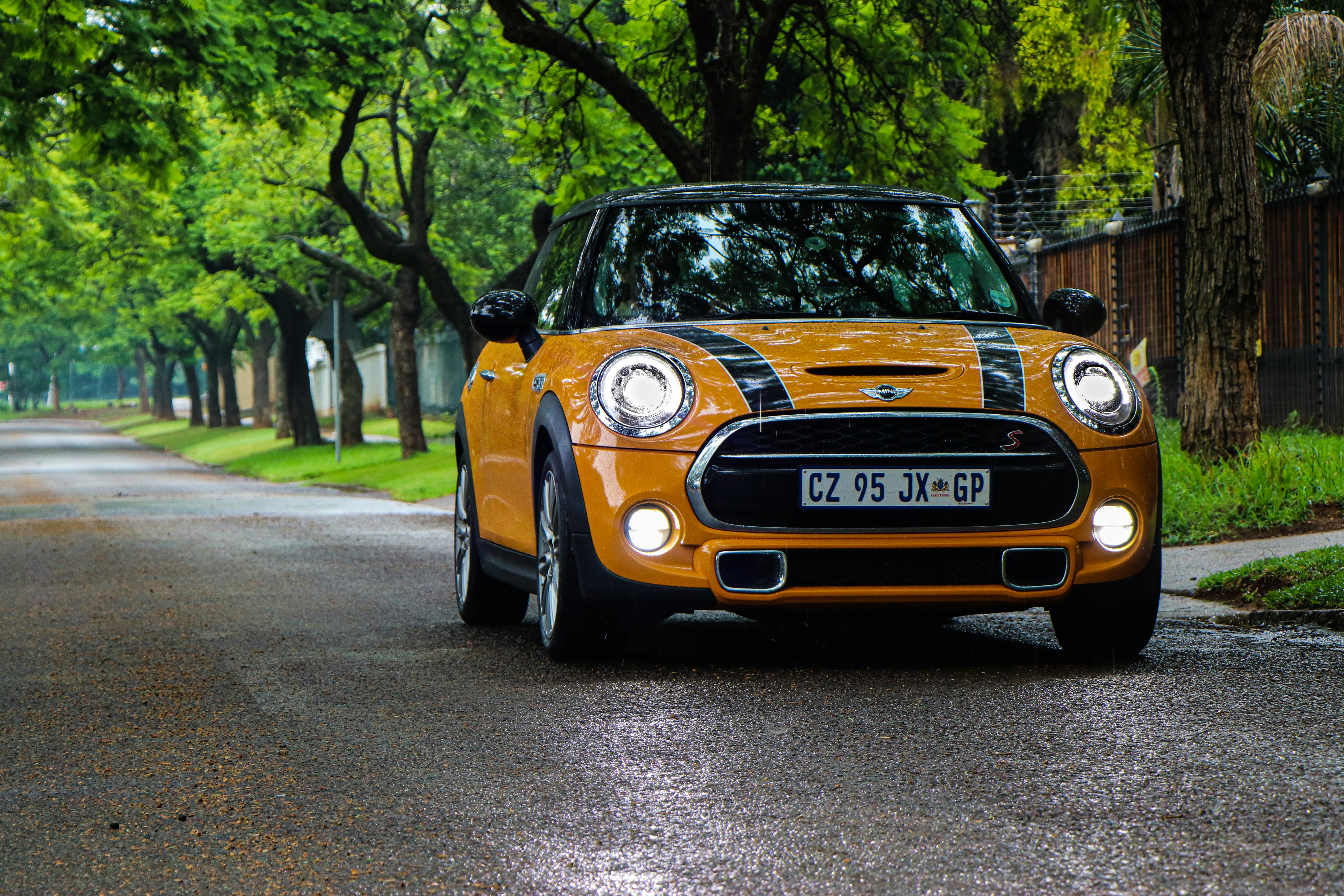 Mini Cooper amarillo y negro estacionado en una carretera de concreto ...