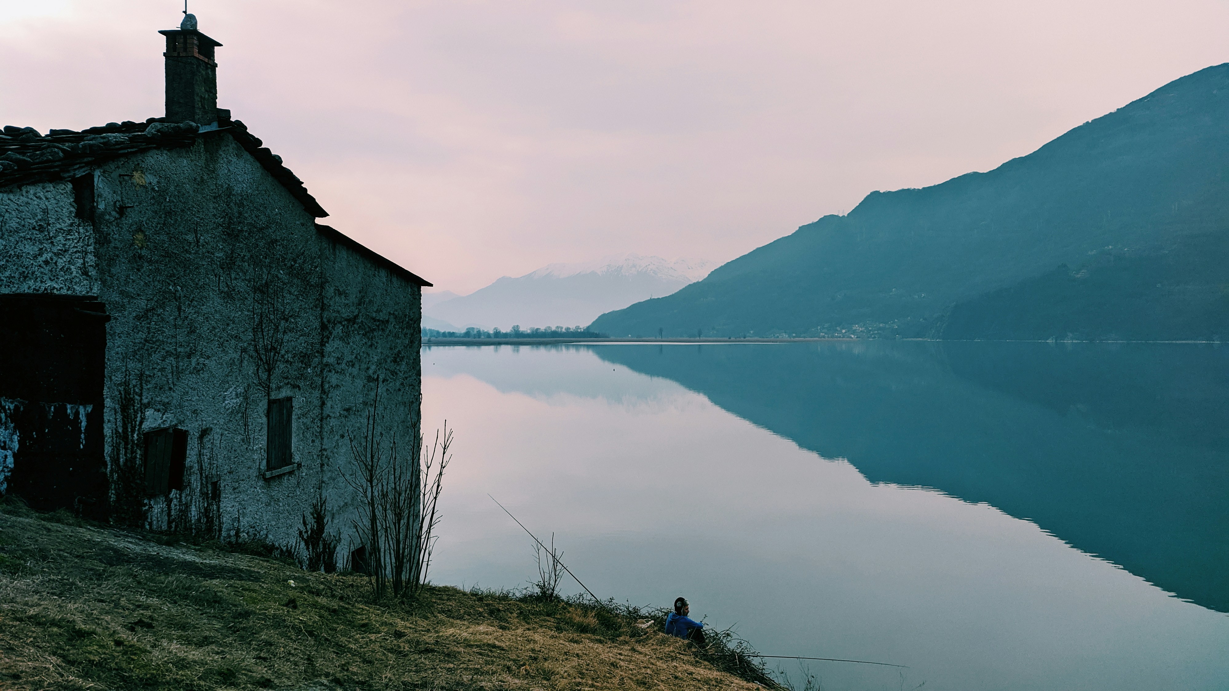 Silent Lakefront: A Weathered Cabin Gaze Over Mirror Waters