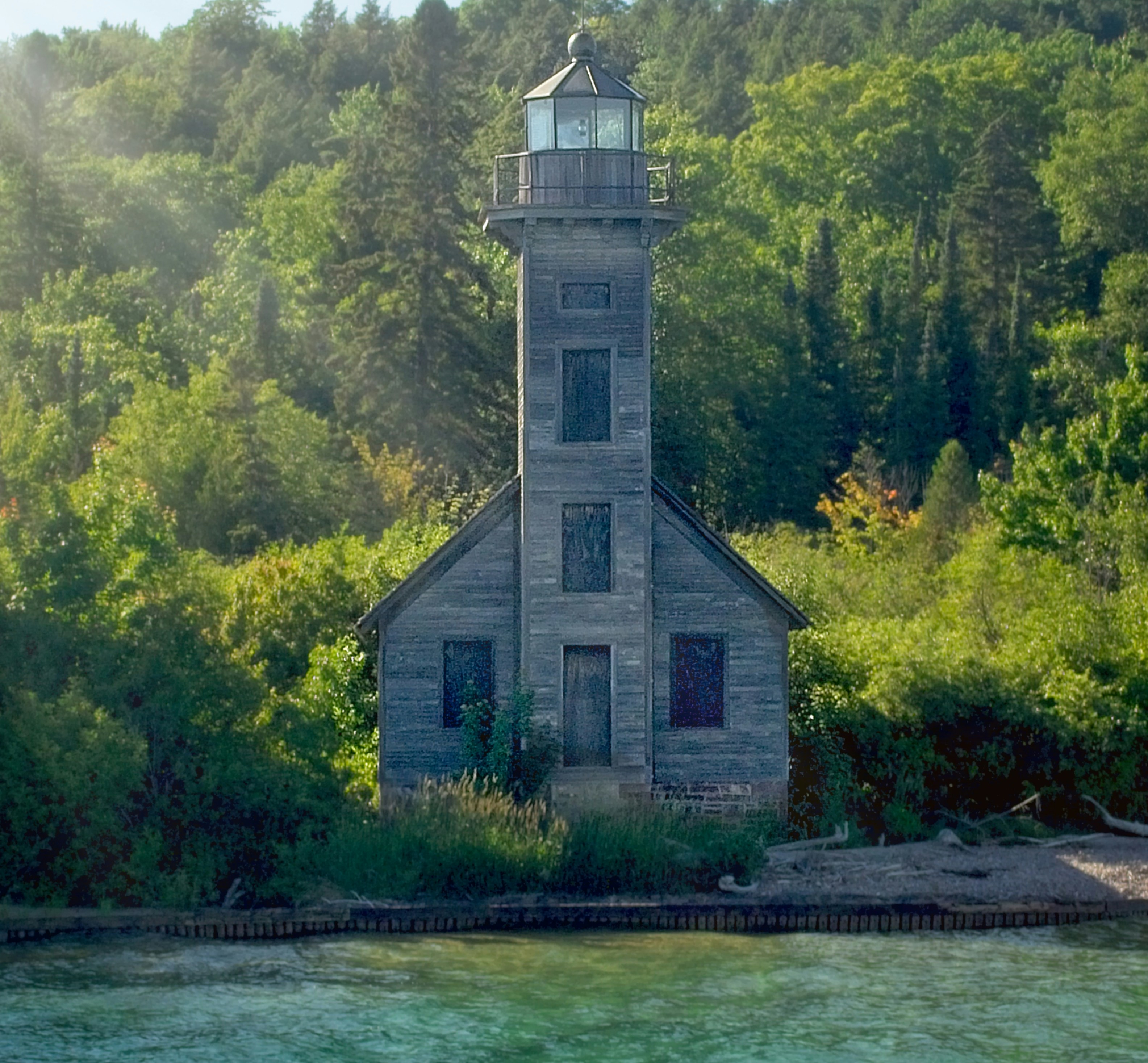 A small light house sitting on top of a lake photo – Free Lake Image on ...