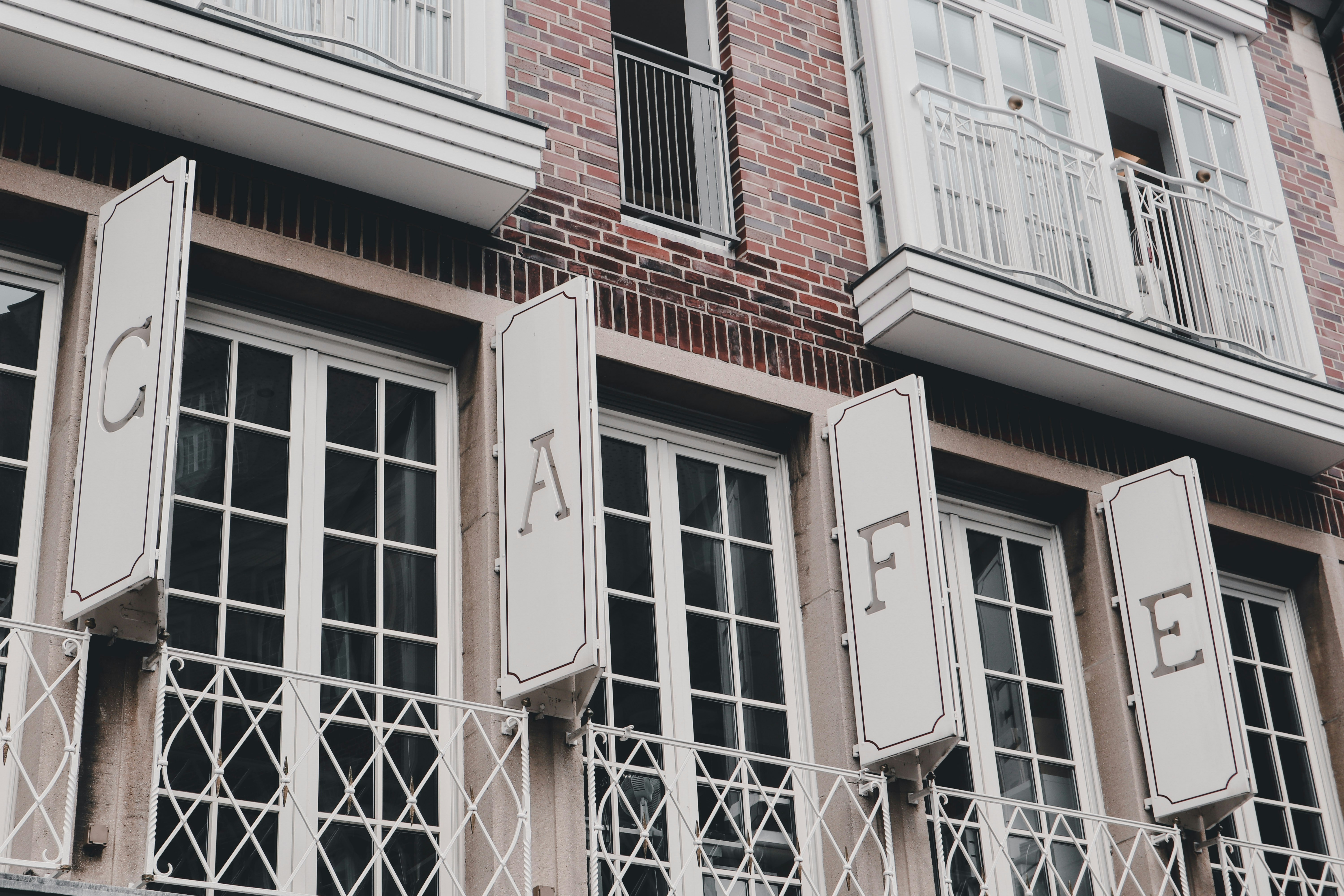 CAFÉ Letters on a Brick-Facade Balcony