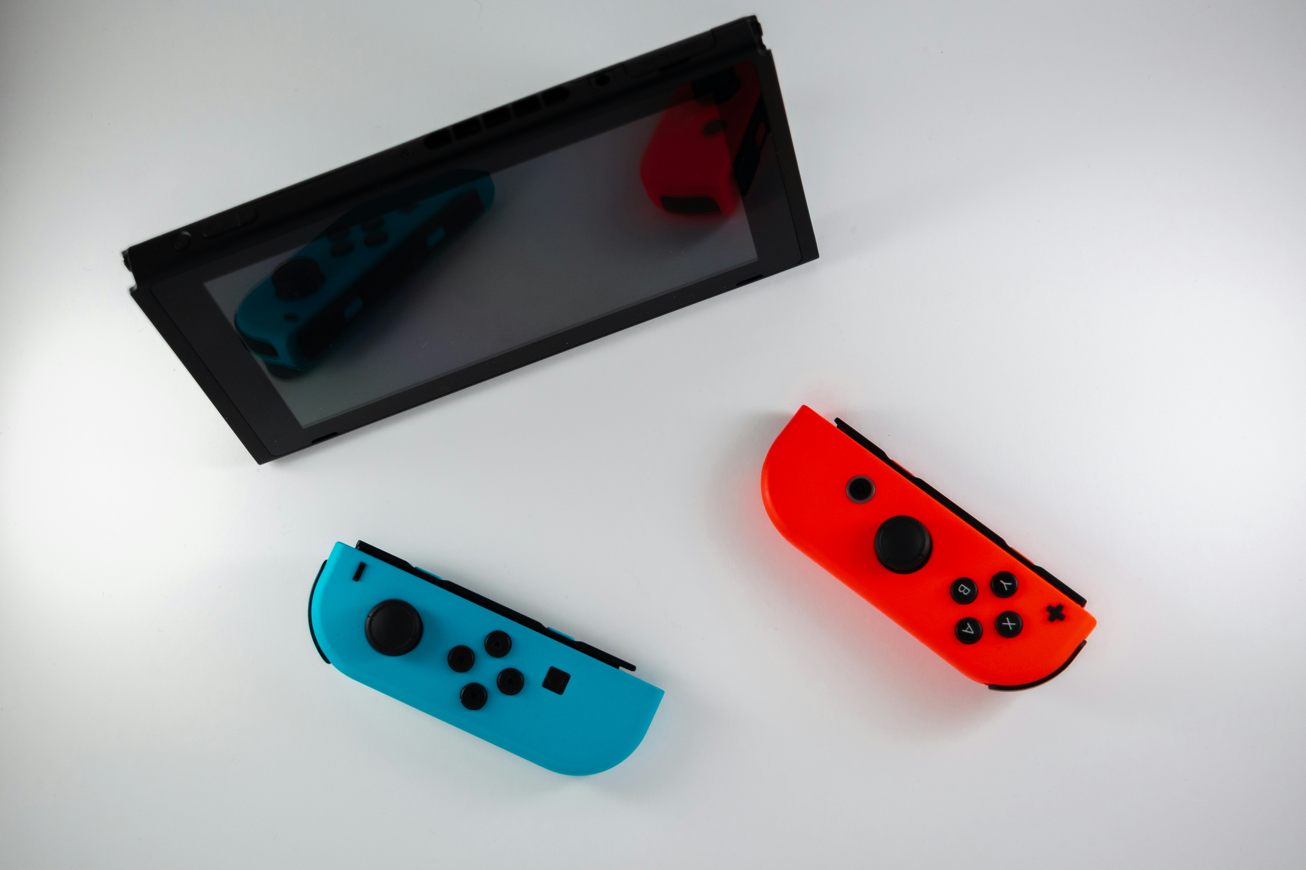 Neon Joy-Cons on a White Stage: A Dual-Color Game Controller Portrait