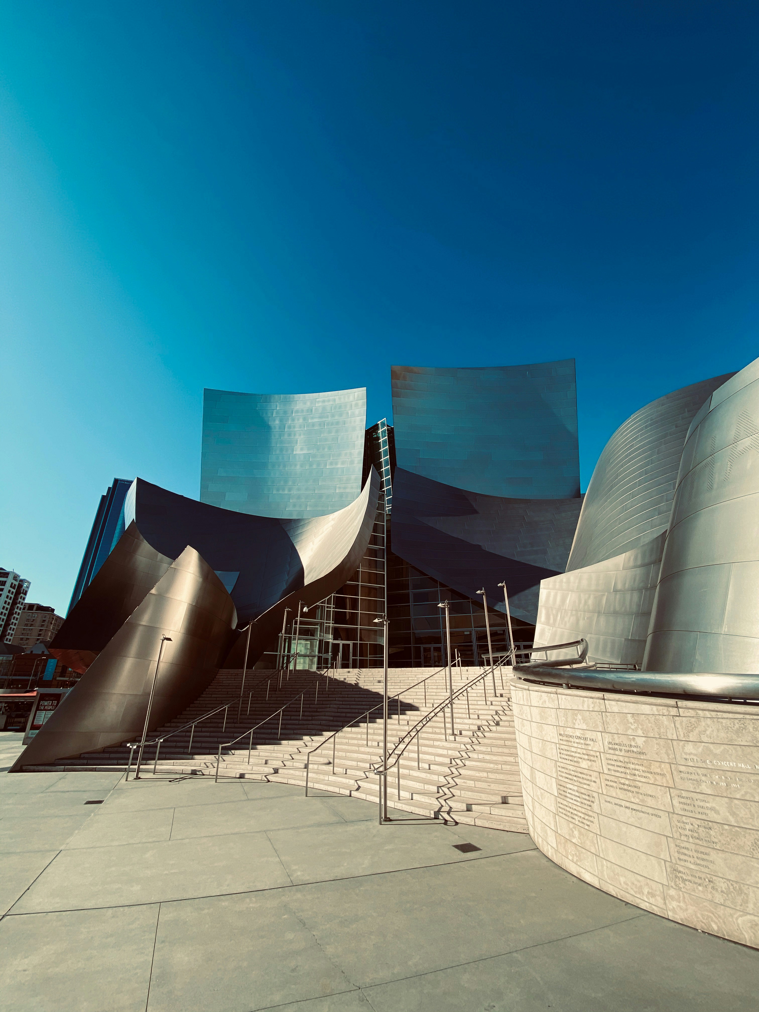 Dynamic architectural forms converge in a striking composition, showcasing metallic surfaces and sharp angles. The scene captures the essence of modern design.