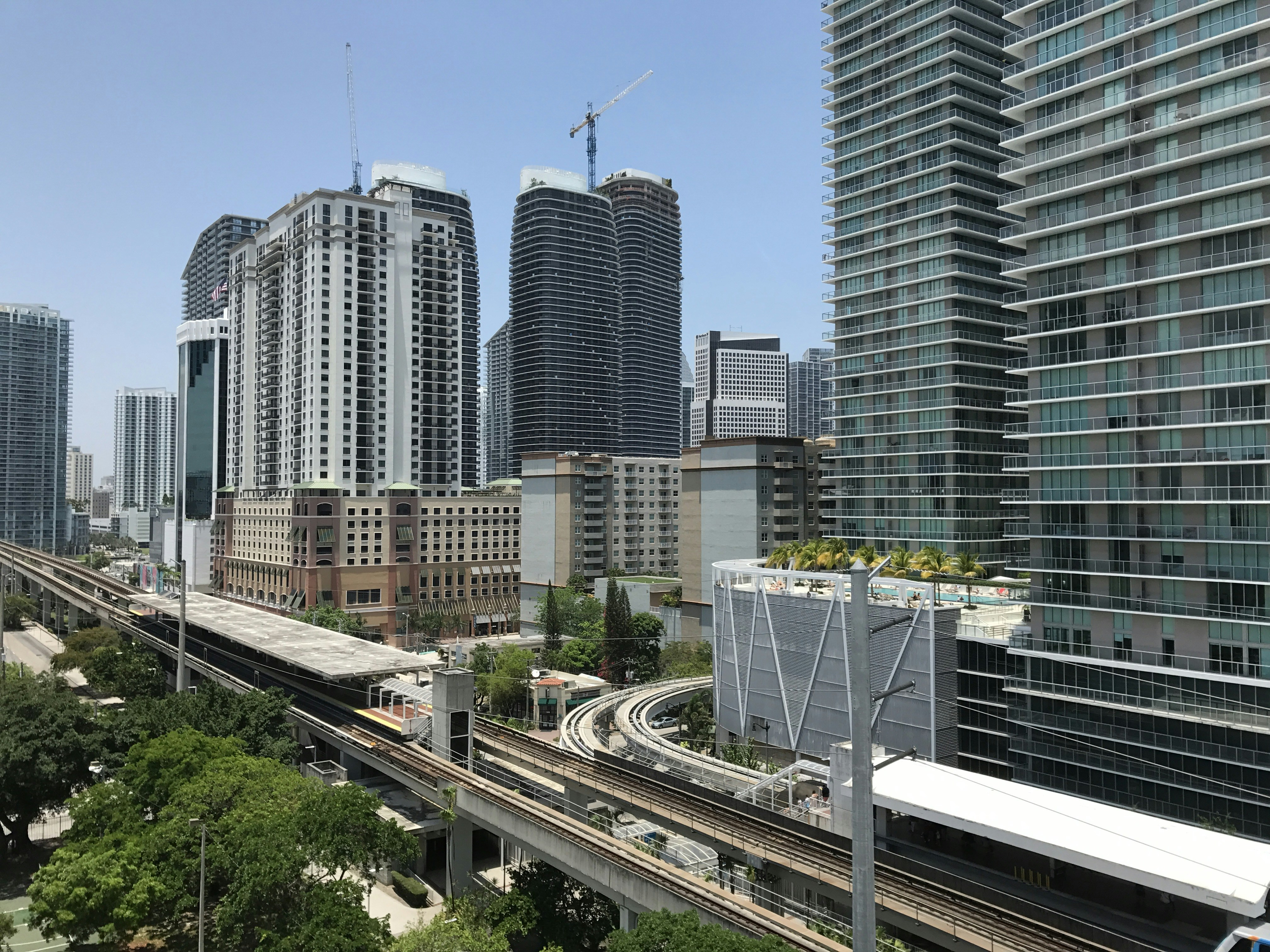 Rails and Glass: A Noon Cityscape of Curved Transit and Skyscrapers