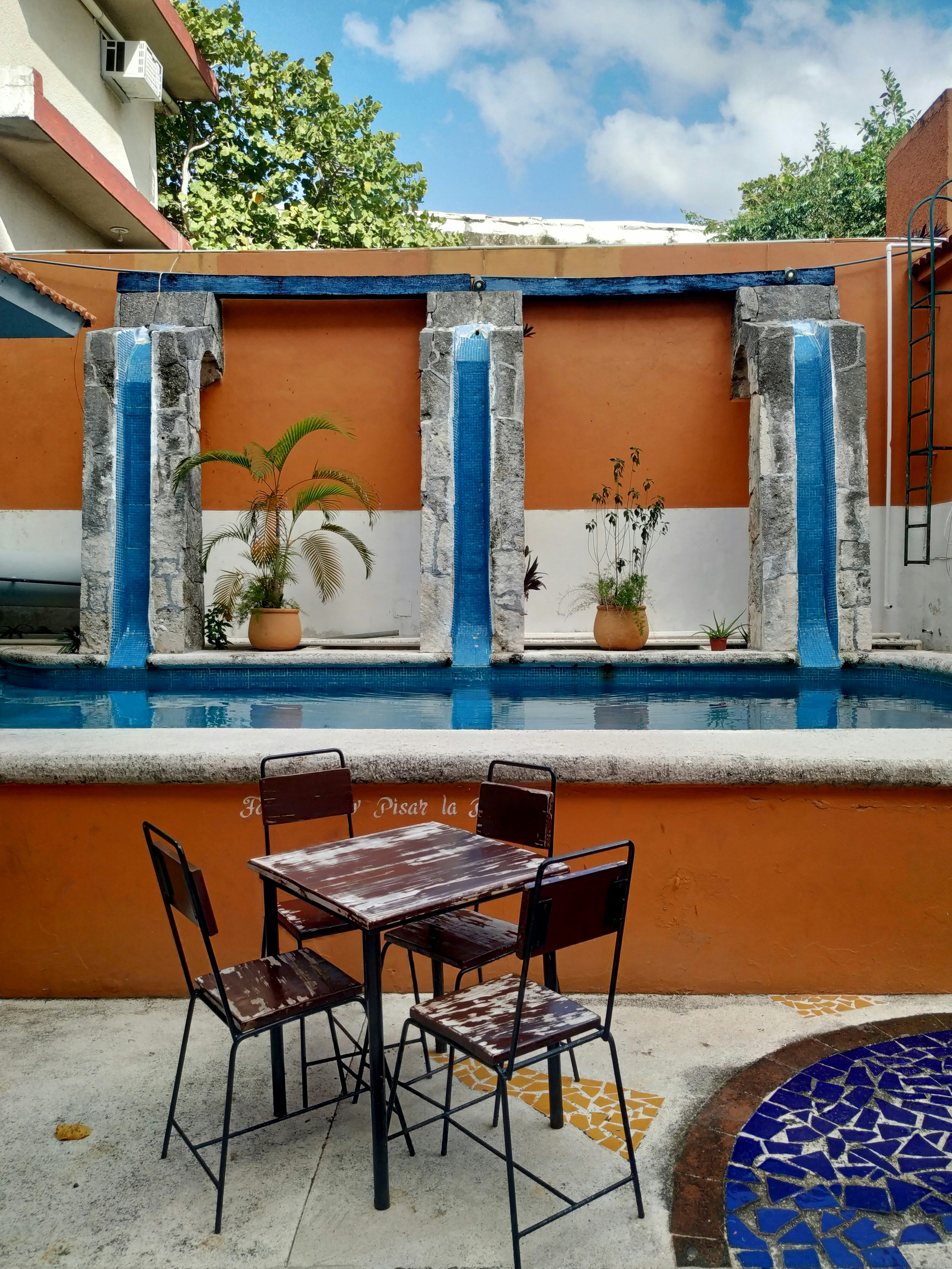 Brown wooden table and chairs near blue and white concrete building ...