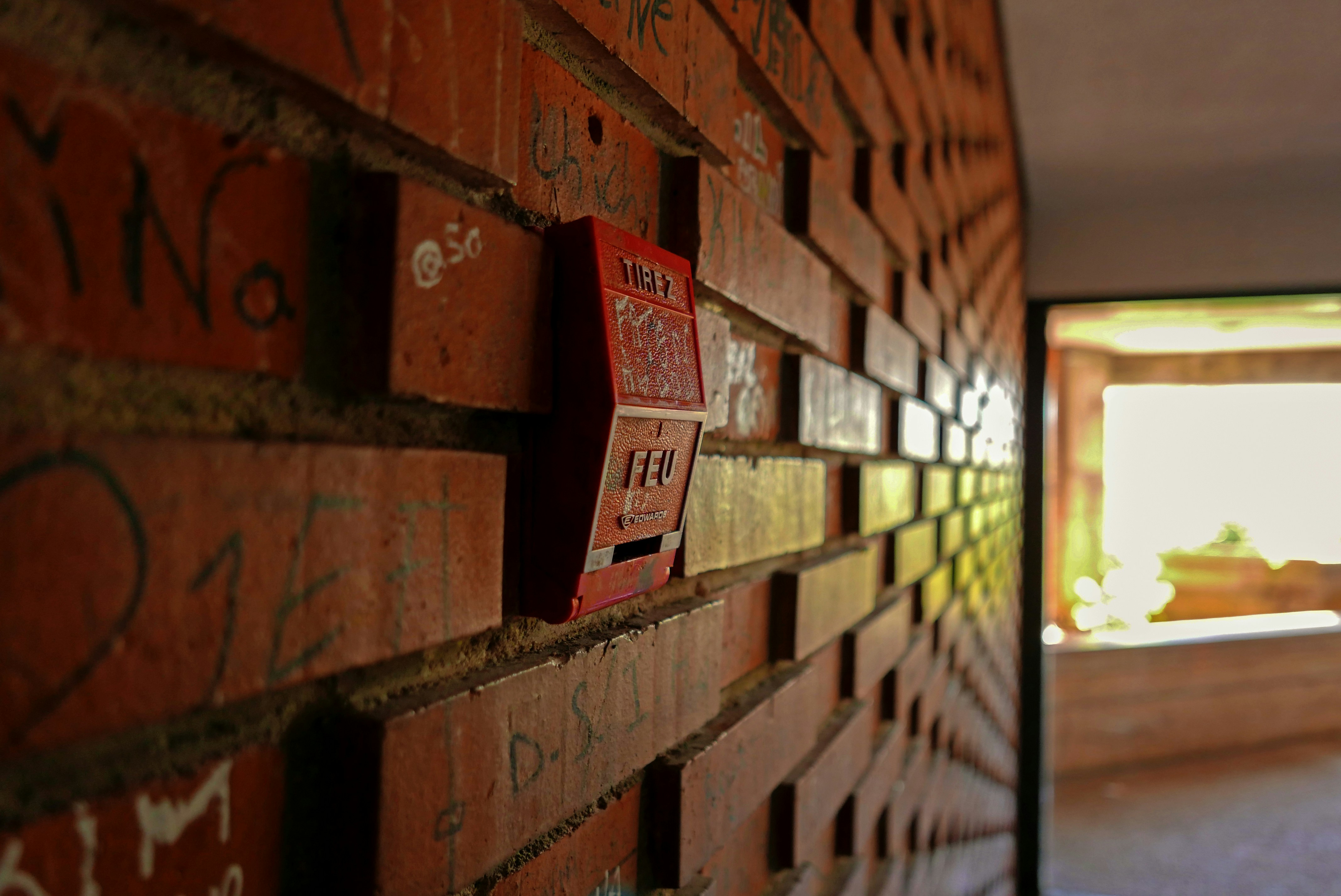 Brick corridor of light: a sunlit ledge through a narrowing hallway