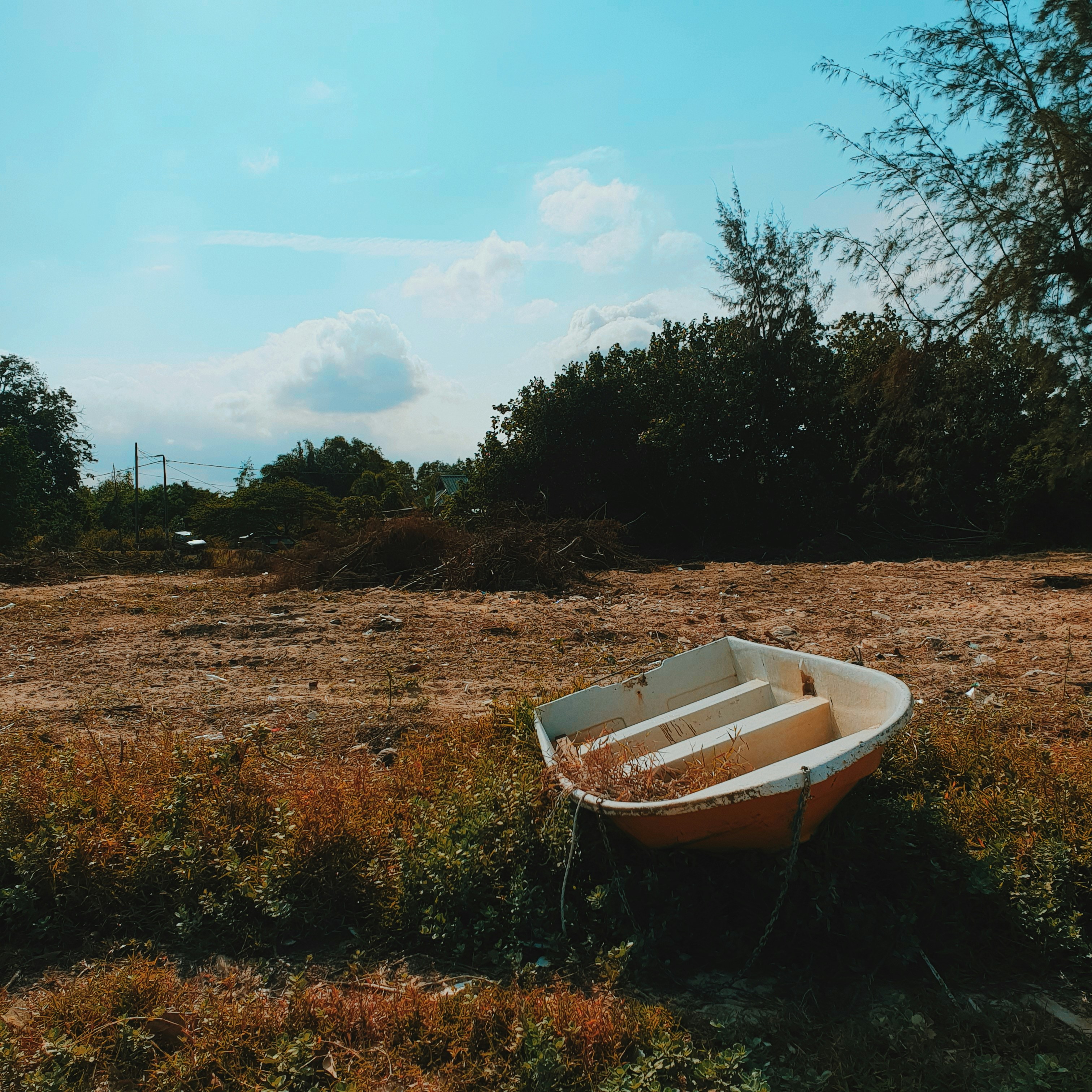 White Boat on a Sunbaked Field Beneath a Bright Sky