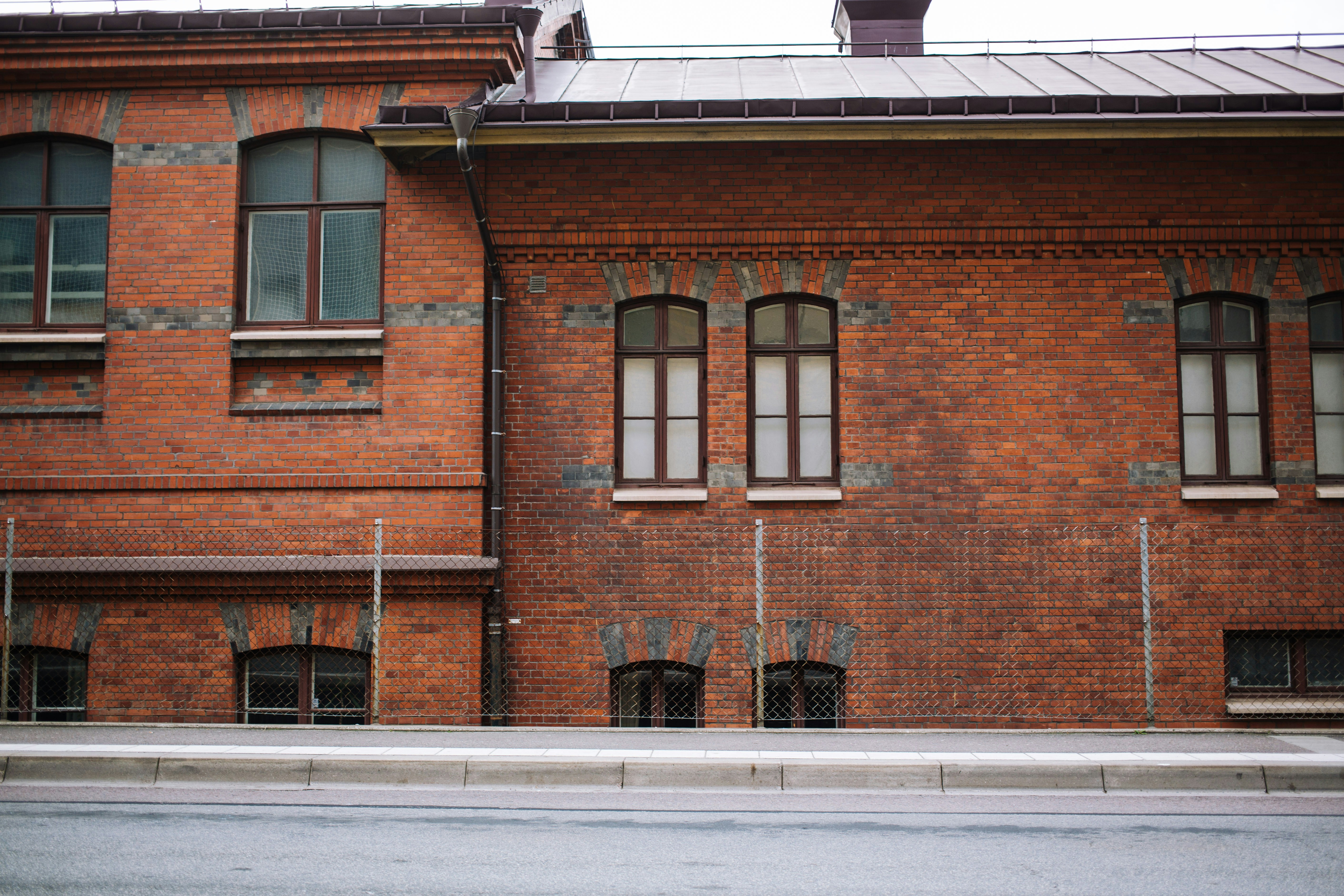 Brick Facade Echoes: Windows, Arches, and Receding Roofline