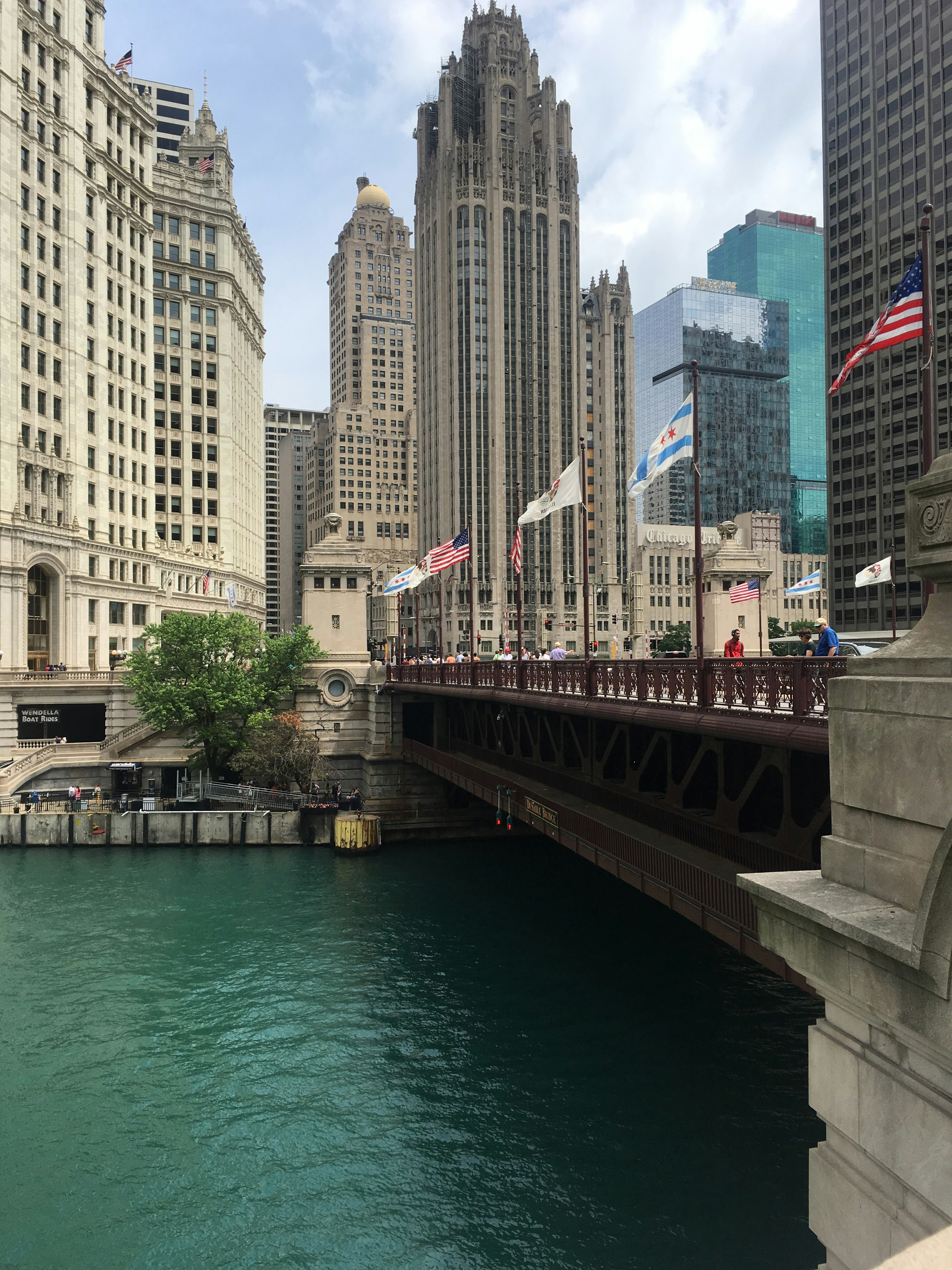 Brown bridge over river near high rise buildings during daytime photo ...