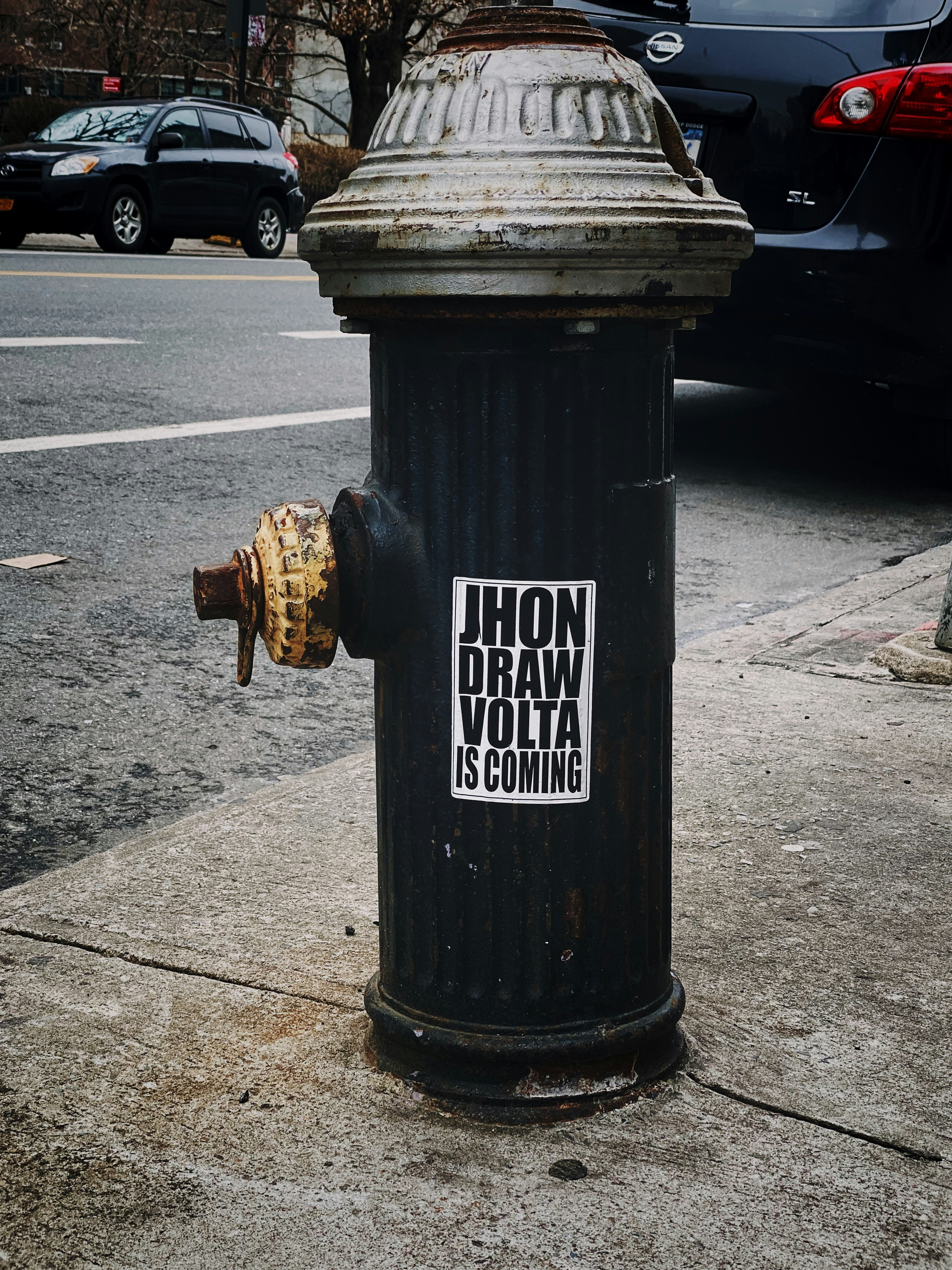 Stickered Hydrant: A Street Corner Message on A Weathered Post