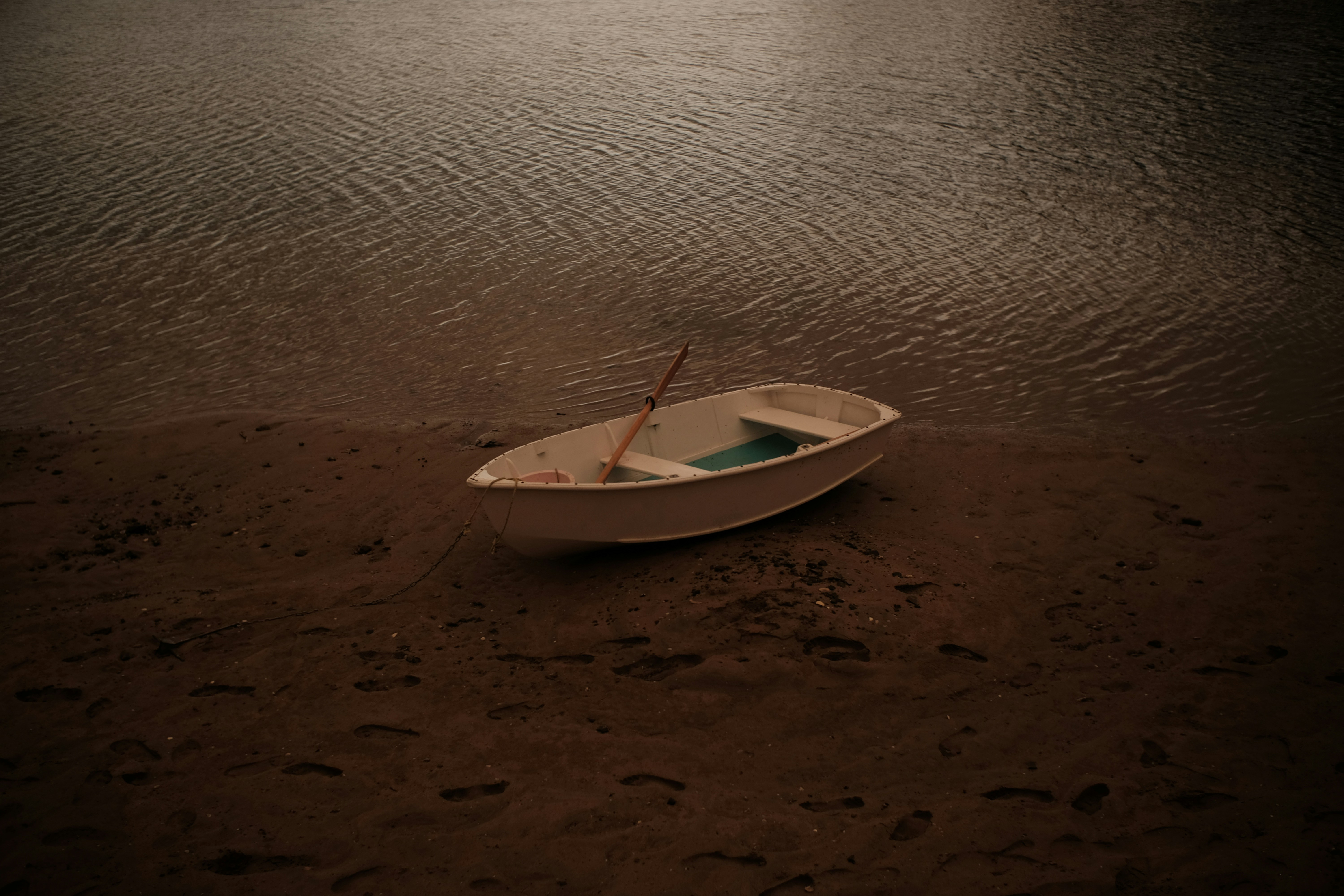 Mute Dusk on the Mudflats: A Solitary Rowboat Among Quiet Ripples