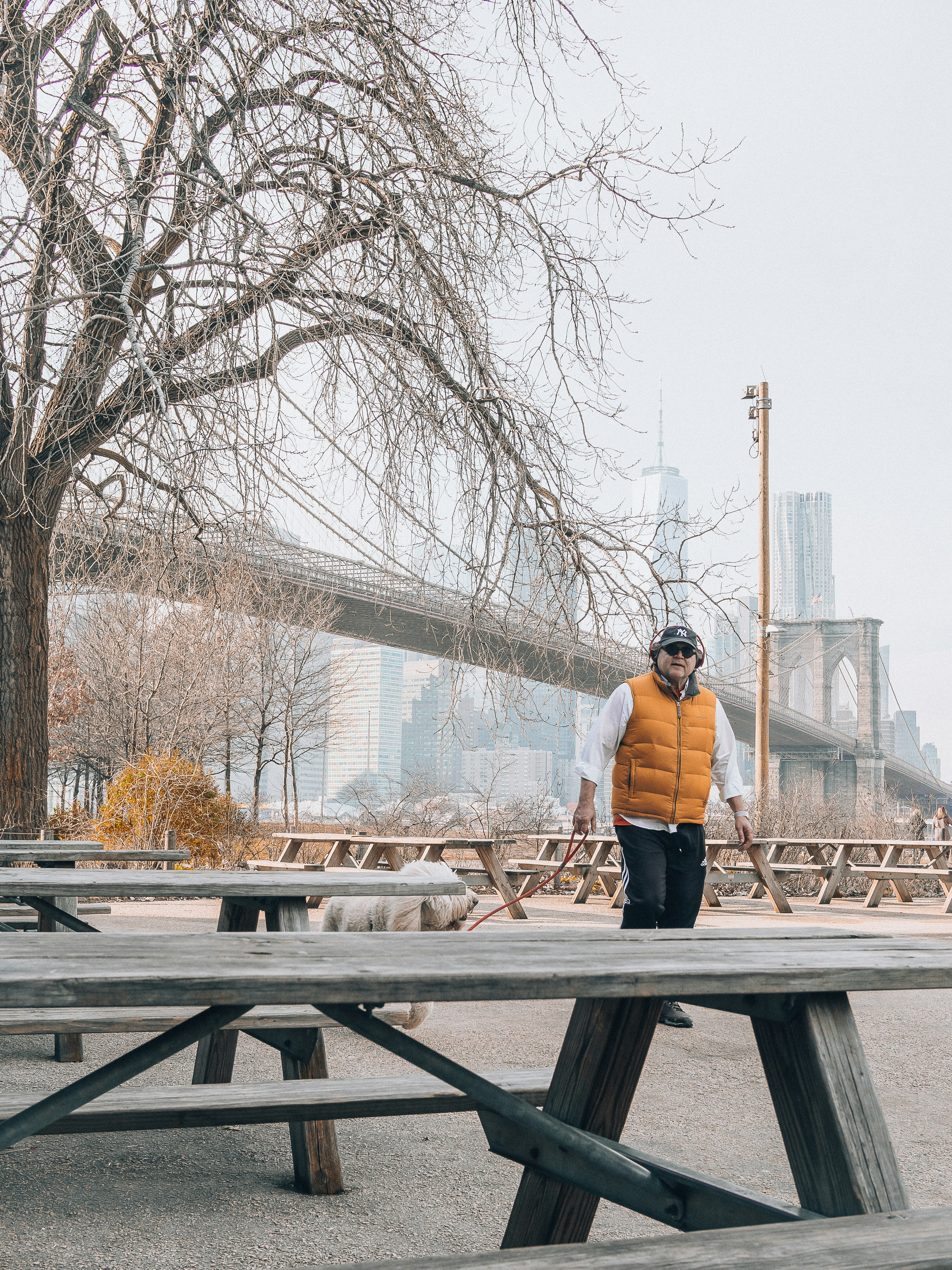 woman in black jacket and brown pants standing on bridge during daytime