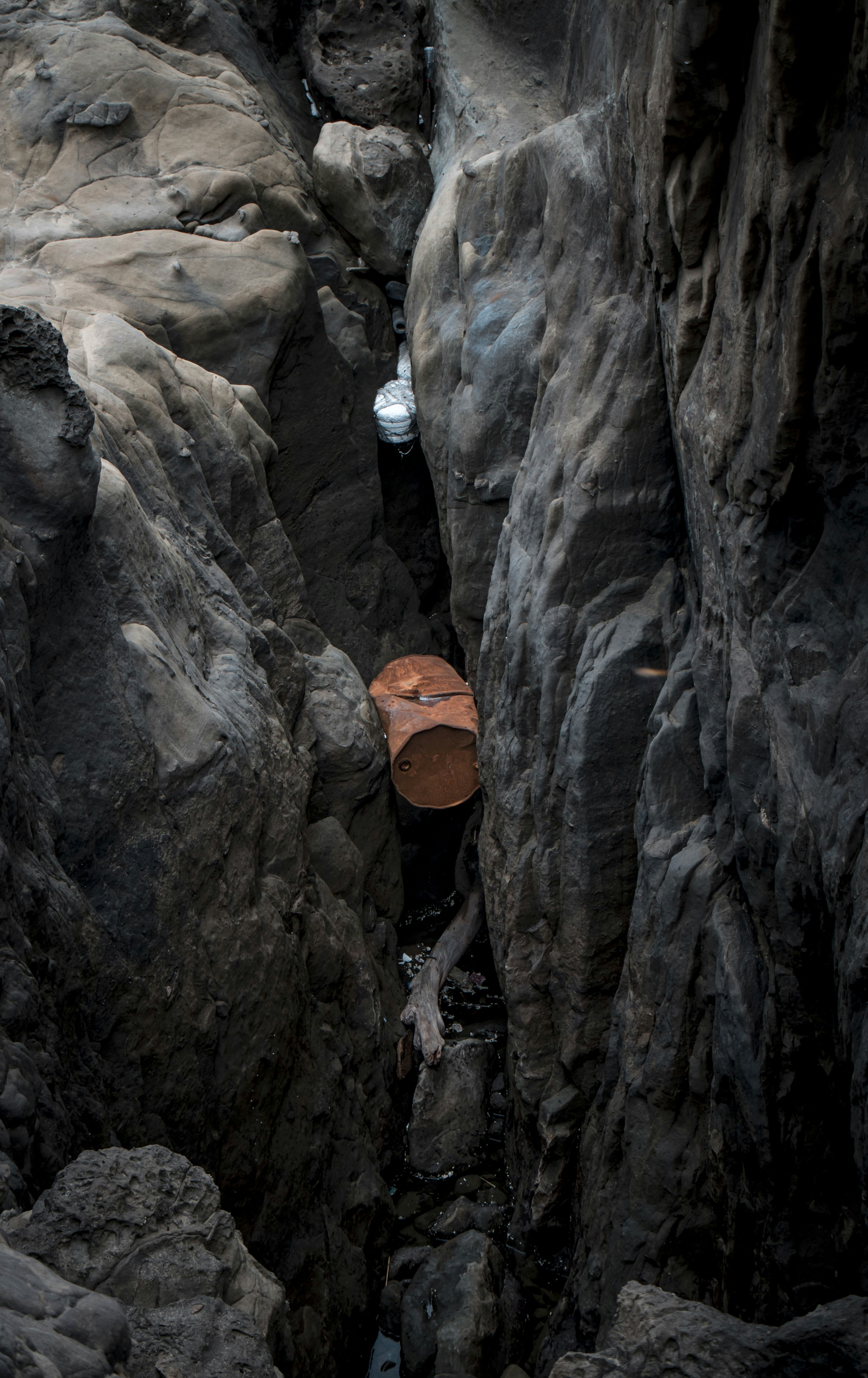 Rusty Barrel Amid Narrow Canyon: A Veil of Stones