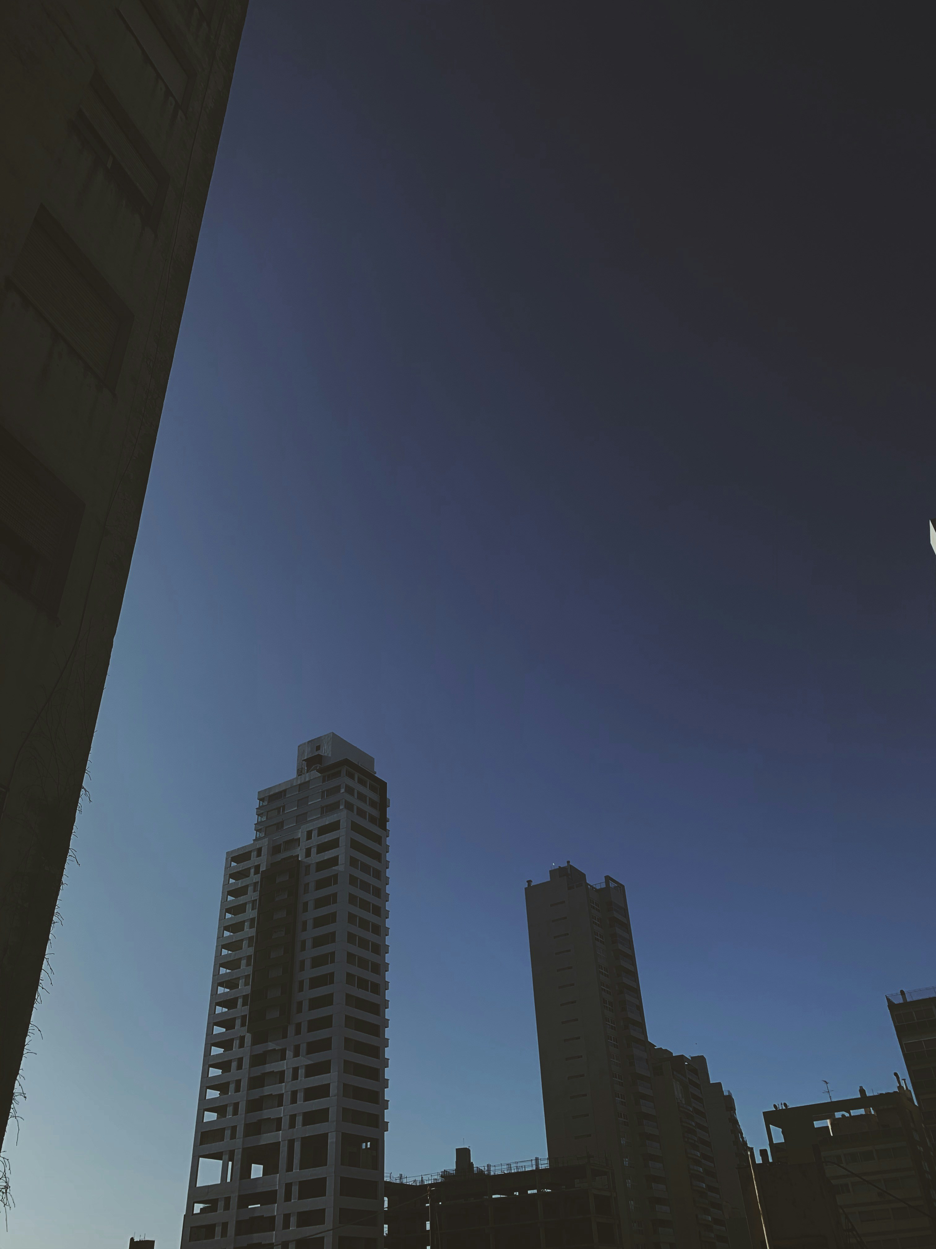 Tall buildings rise against a gradient twilight sky, showcasing urban architecture. The scene captures the transition from day to night.