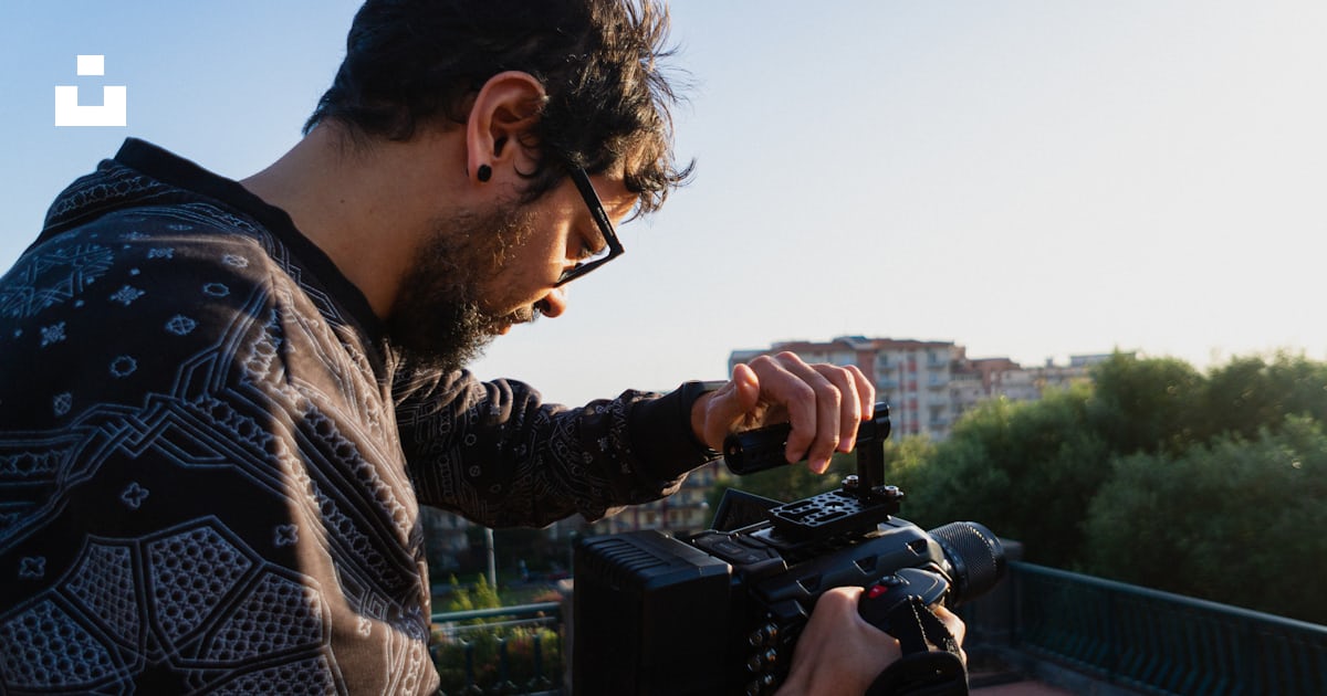검은 Dslr 카메라를 들고 검은 색과 흰색 격자 무늬 드레스 셔츠를 입은 남자 사진 Unsplash의 무료 사진 이미지