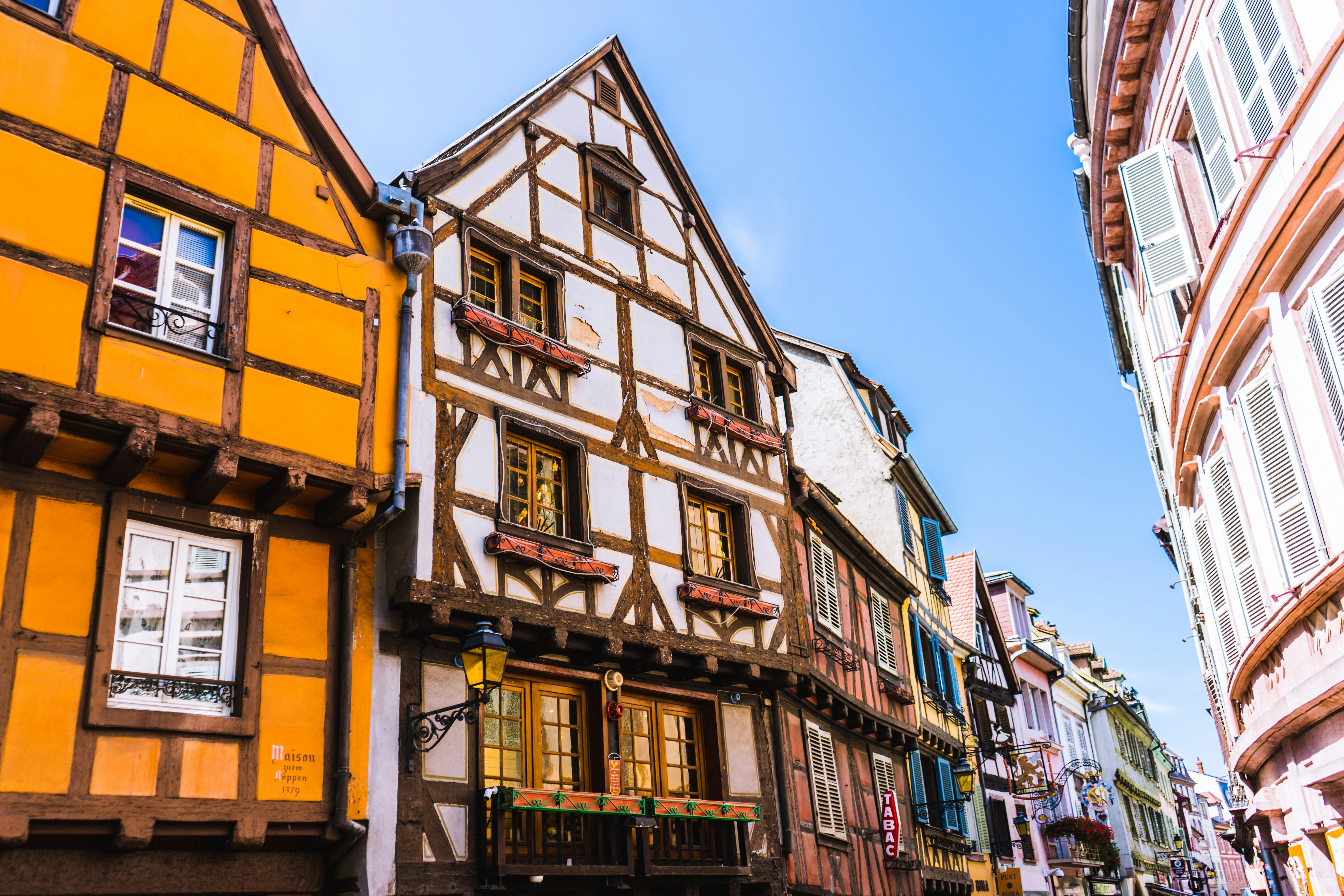 Colorful half-timbered buildings under a clear blue sky in a quaint European town.
