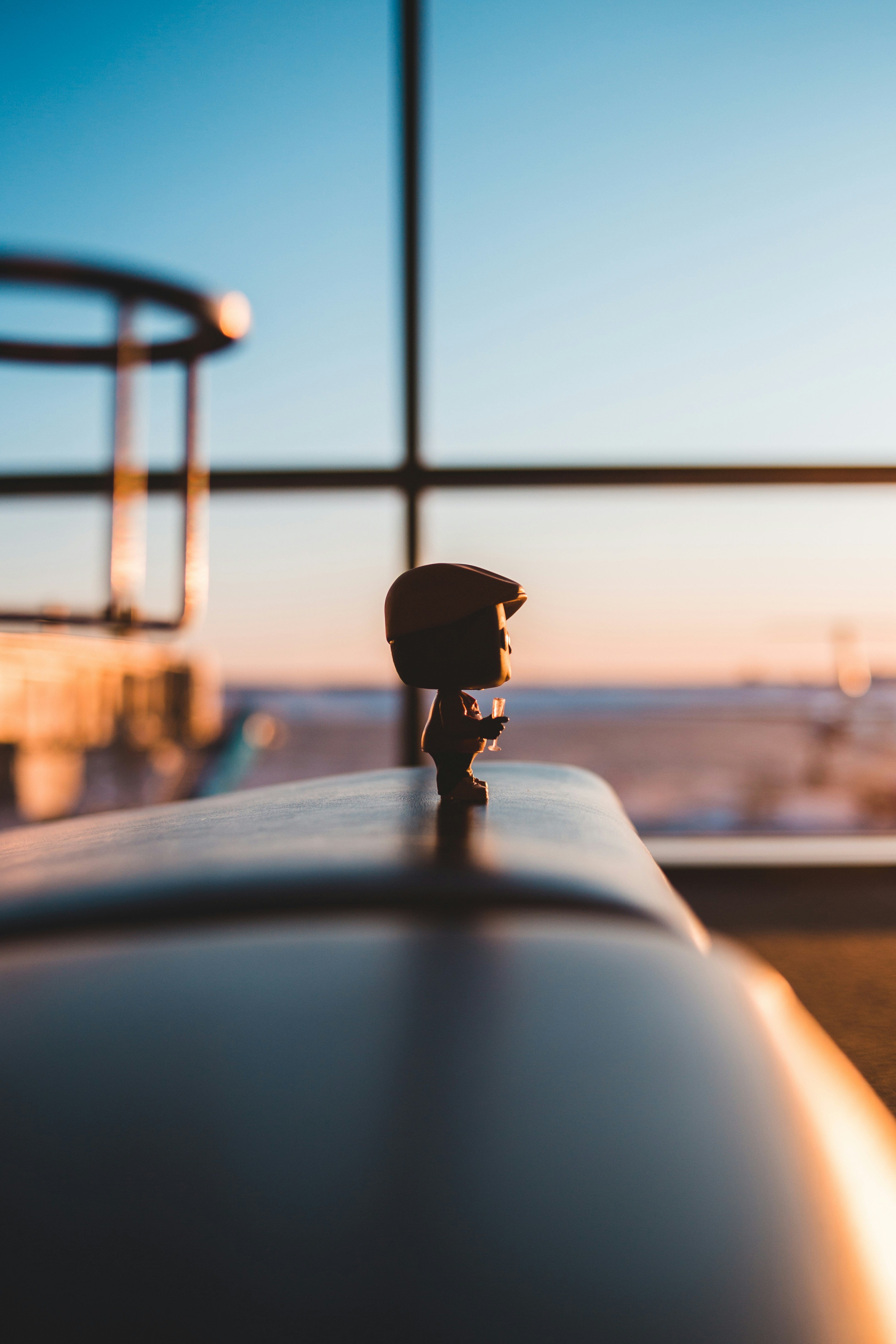 Tiny Pilot on a Sunlit Rail at Dusk
