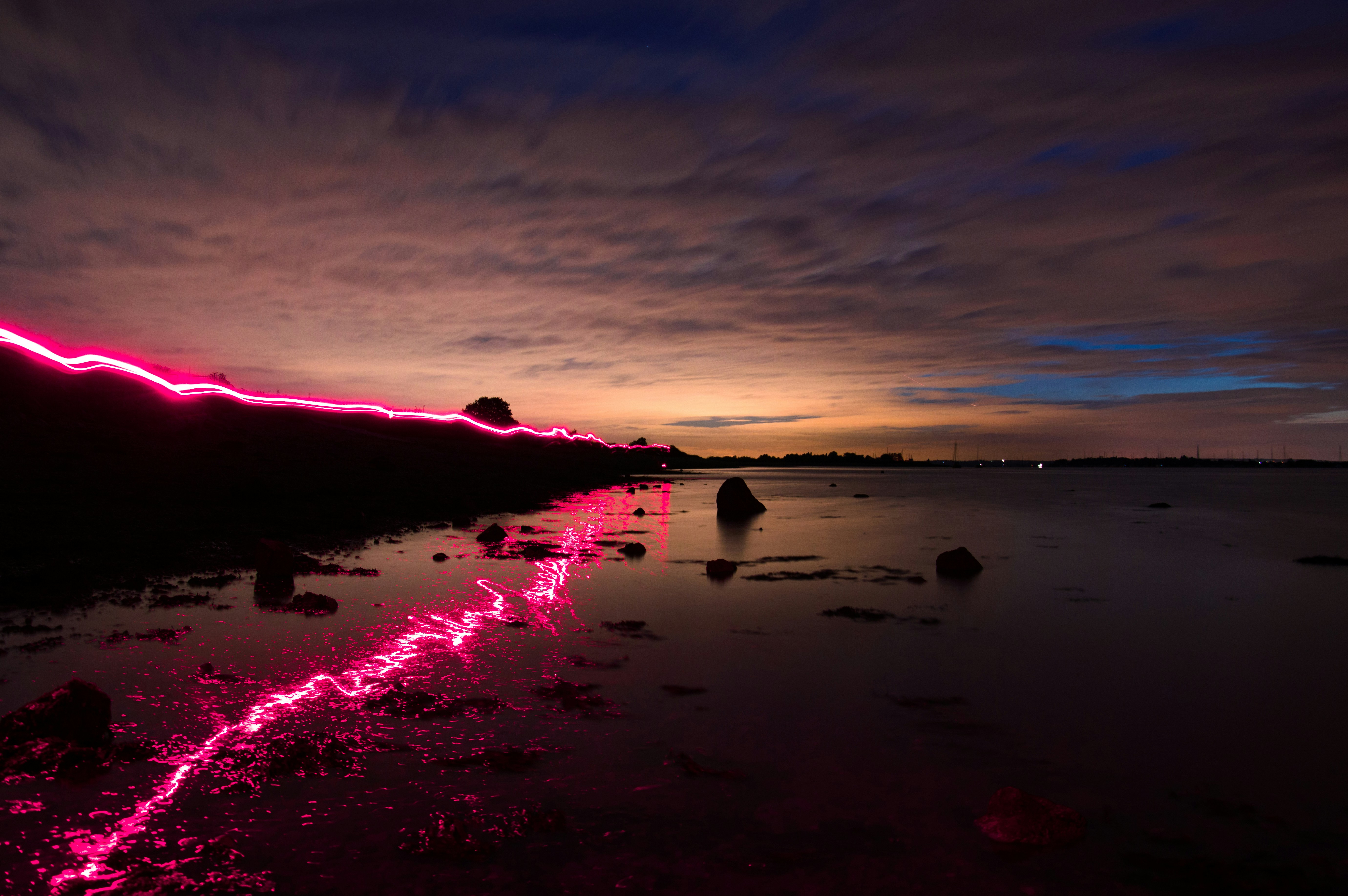 Neon Ripple Across a Quiet Dusk Shore