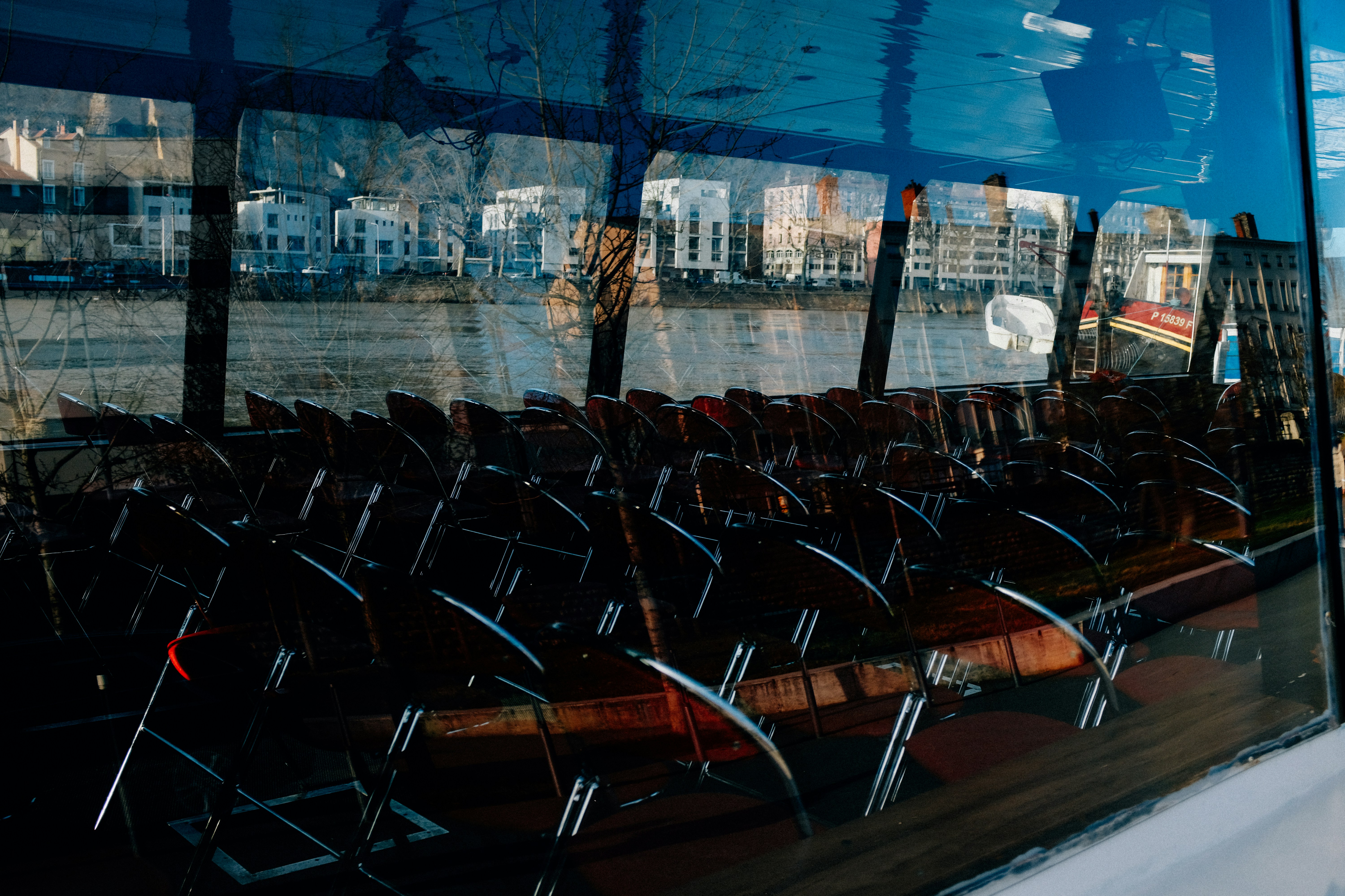 Reflection of a Seated Row: Boats, Windows and Waterfront in Glass