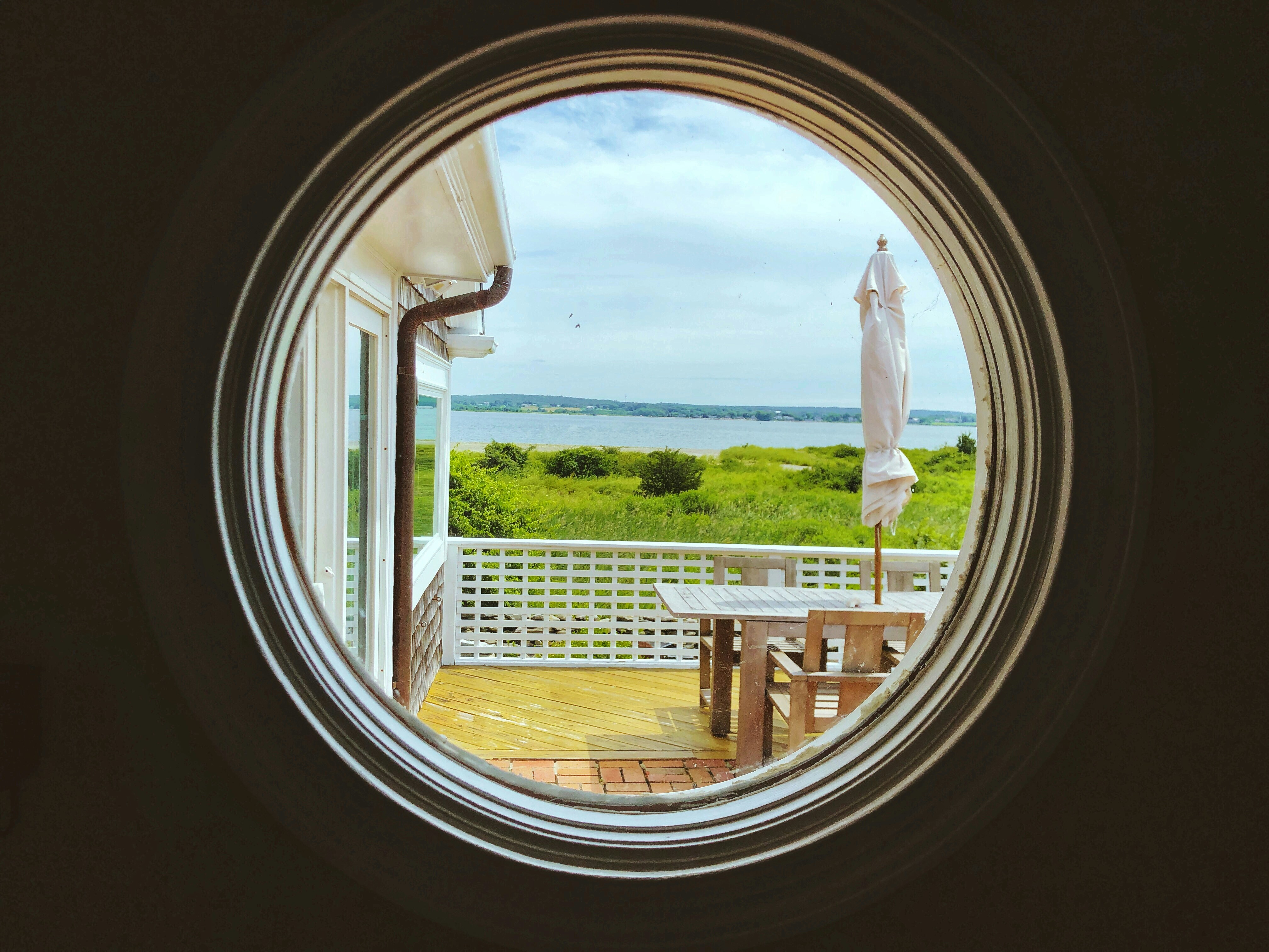 Circular View: Coastal Terrace Framed by a Vessel Ring