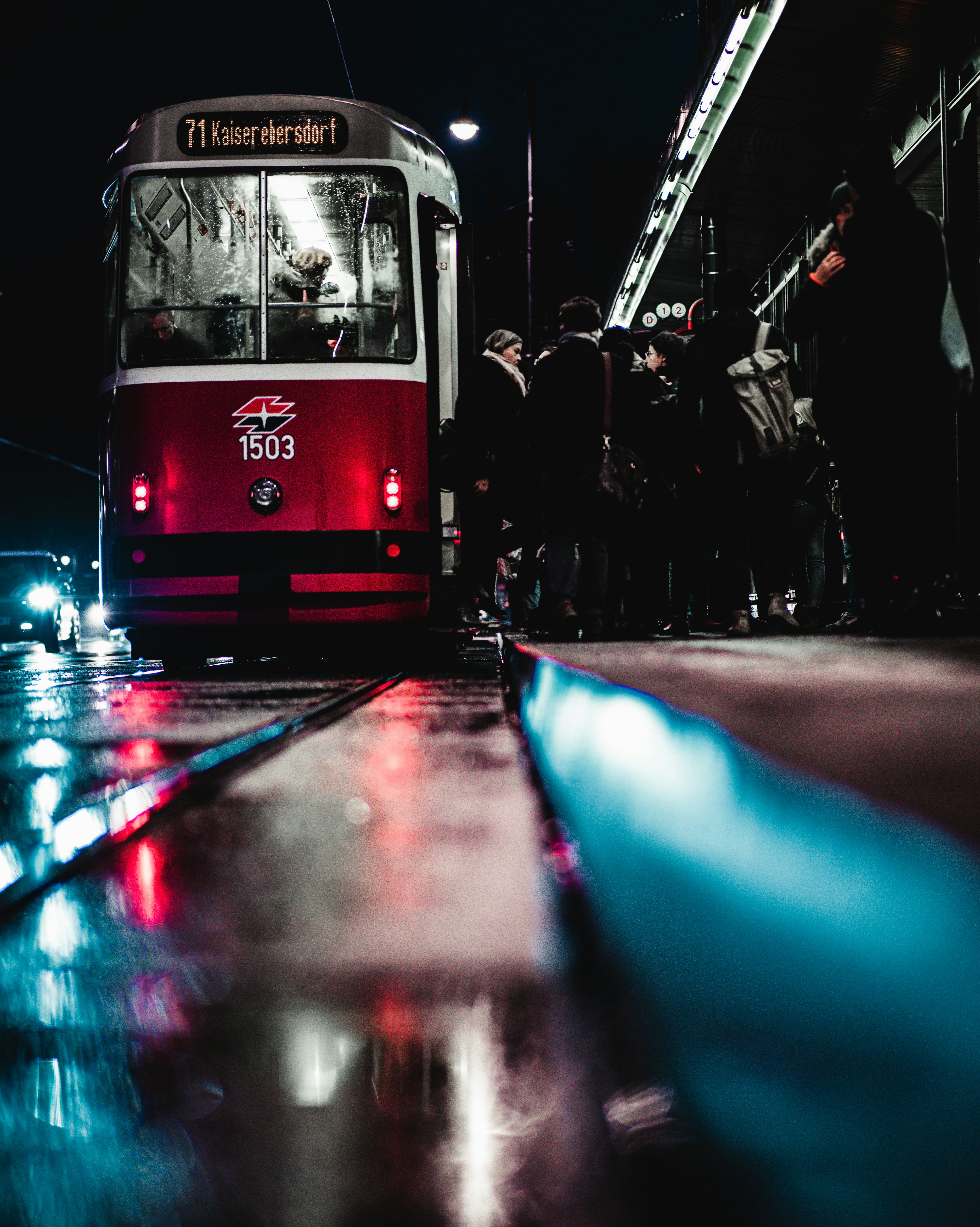 Midnight Tram at a Rain-Slick Platform: Neon Reflections and Crowded Edge