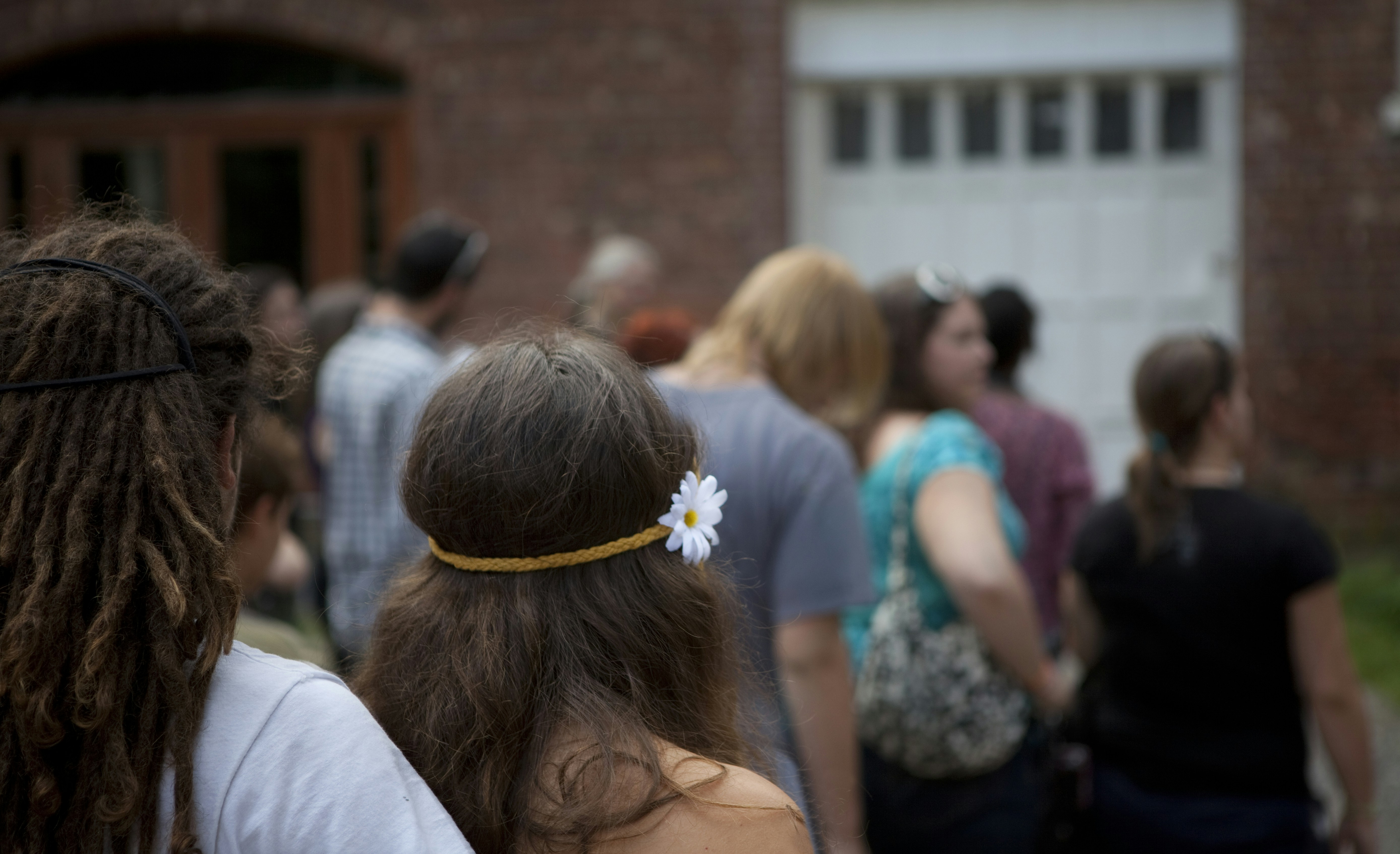 Bloom in the Crowd: A Foreground Flower Framing the Gathered Scene