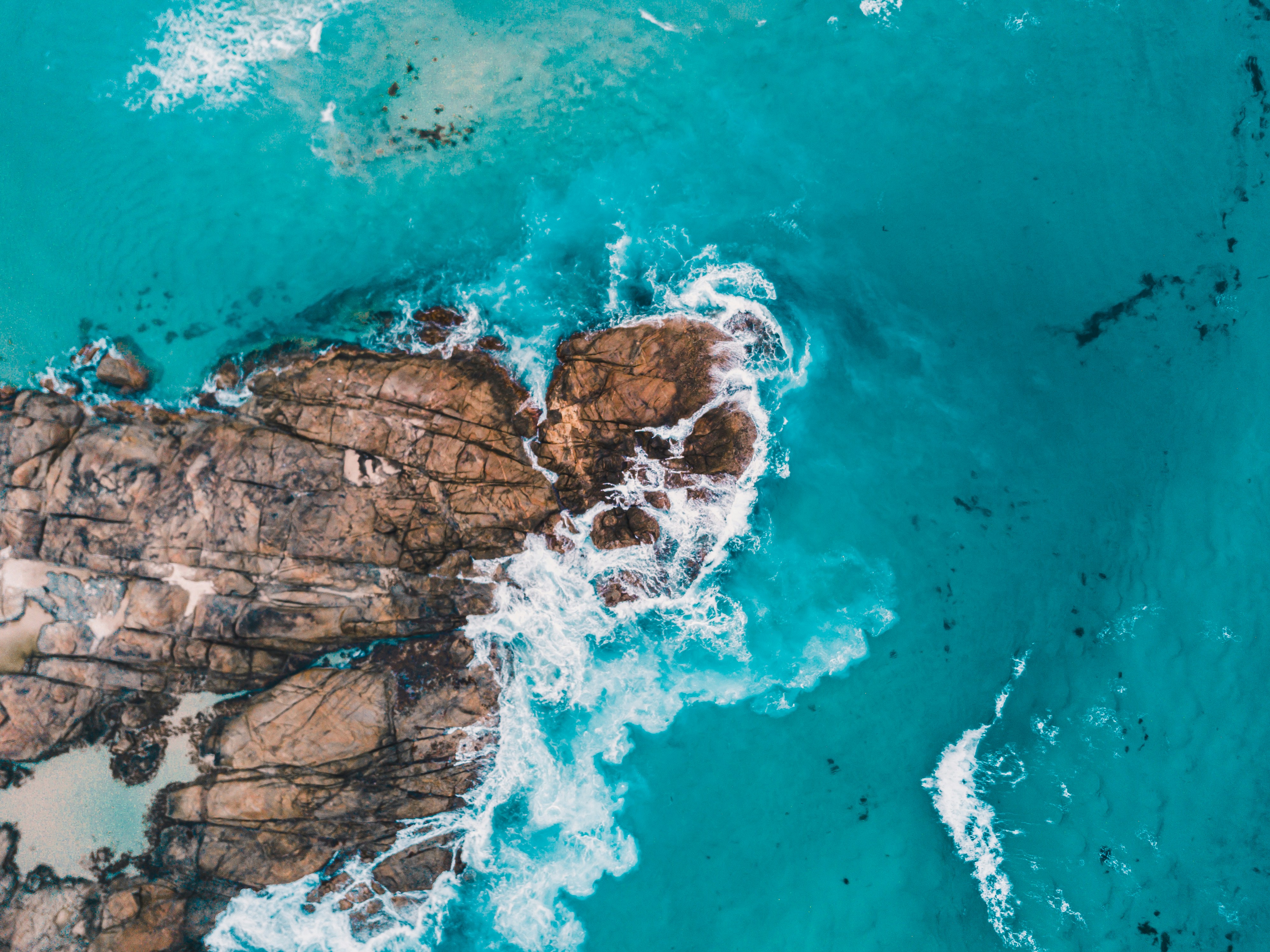 Brown rock formation on body of water during daytime photo – Free ...