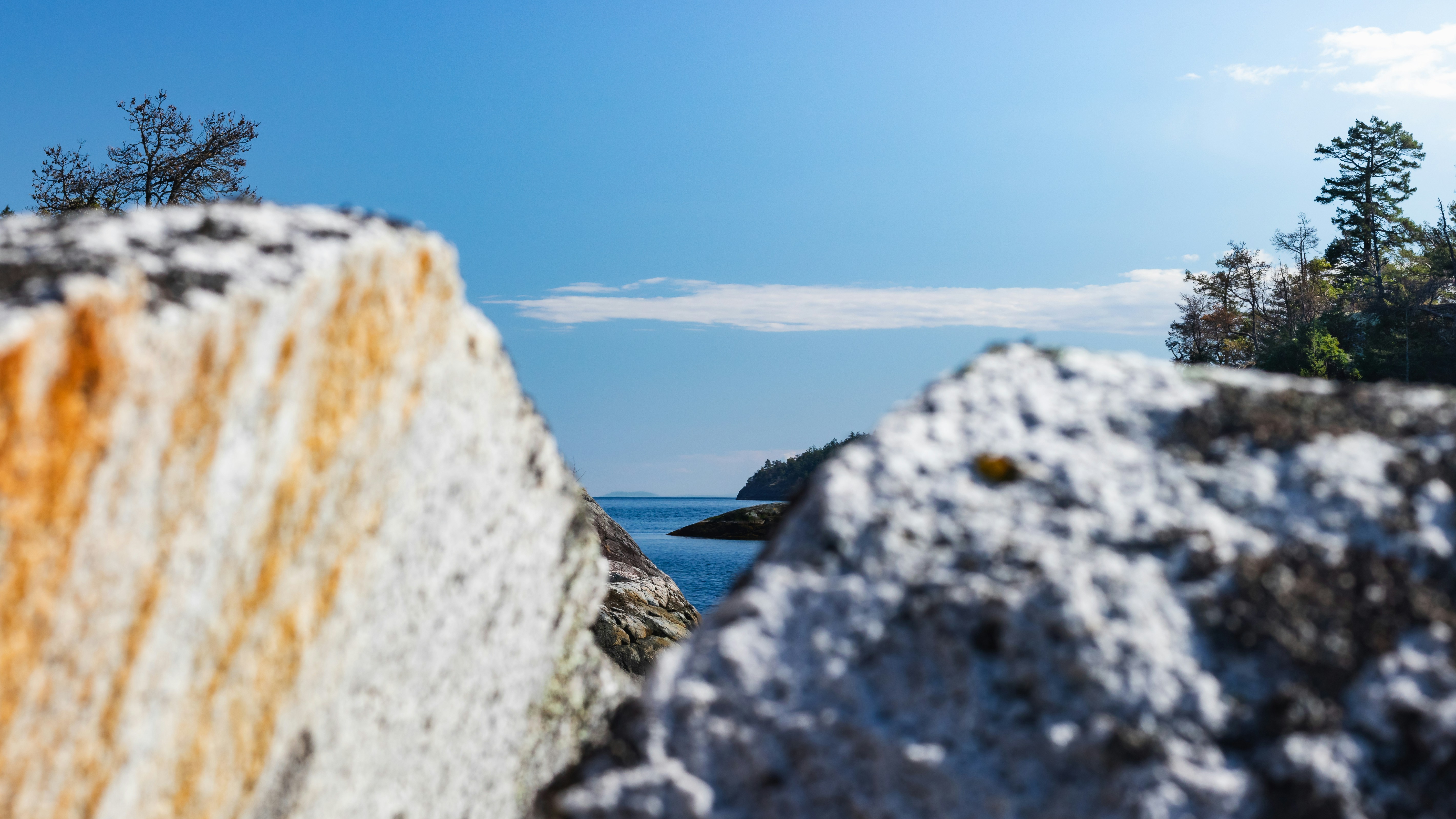 White and brown rock formation near body of water during daytime photo ...