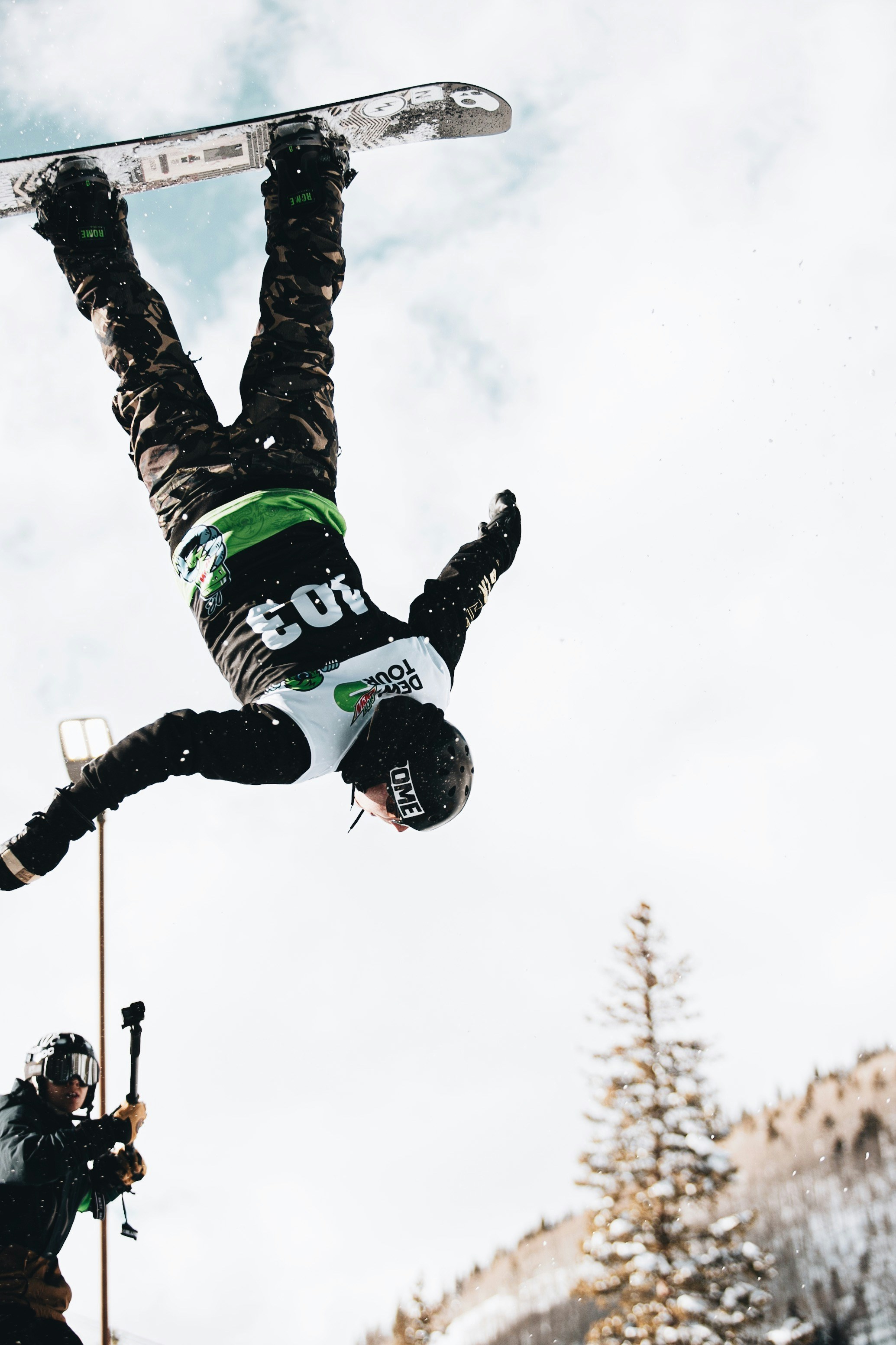 Inverted Leap Over Powder: A Snowboarder’s Mid-Air Line