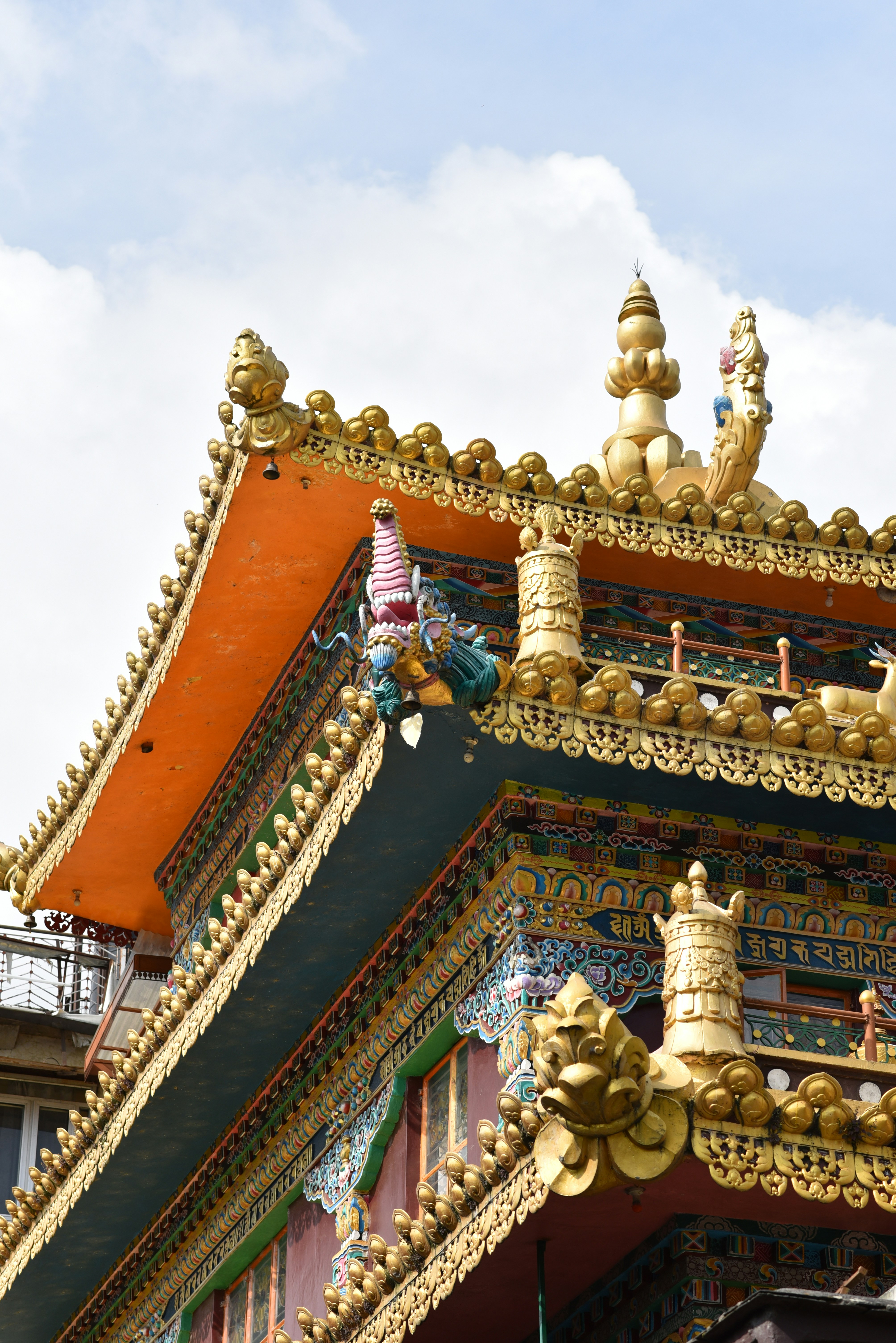 Intricately designed temple rooftop adorned with vibrant colors and golden embellishments, showcasing traditional craftsmanship. A symbol of cultural heritage.