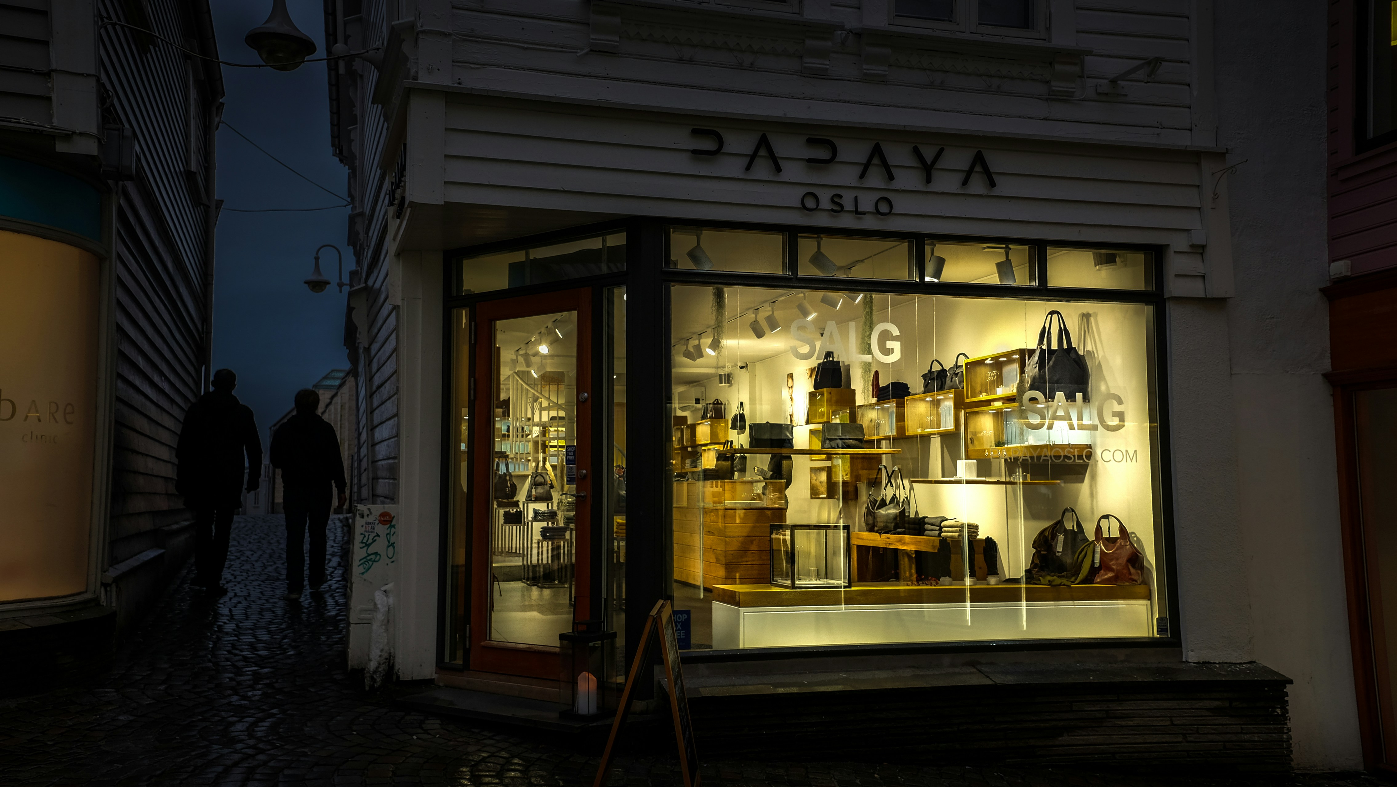 Shopfront Glow Across a Quiet Cobblestone Alley