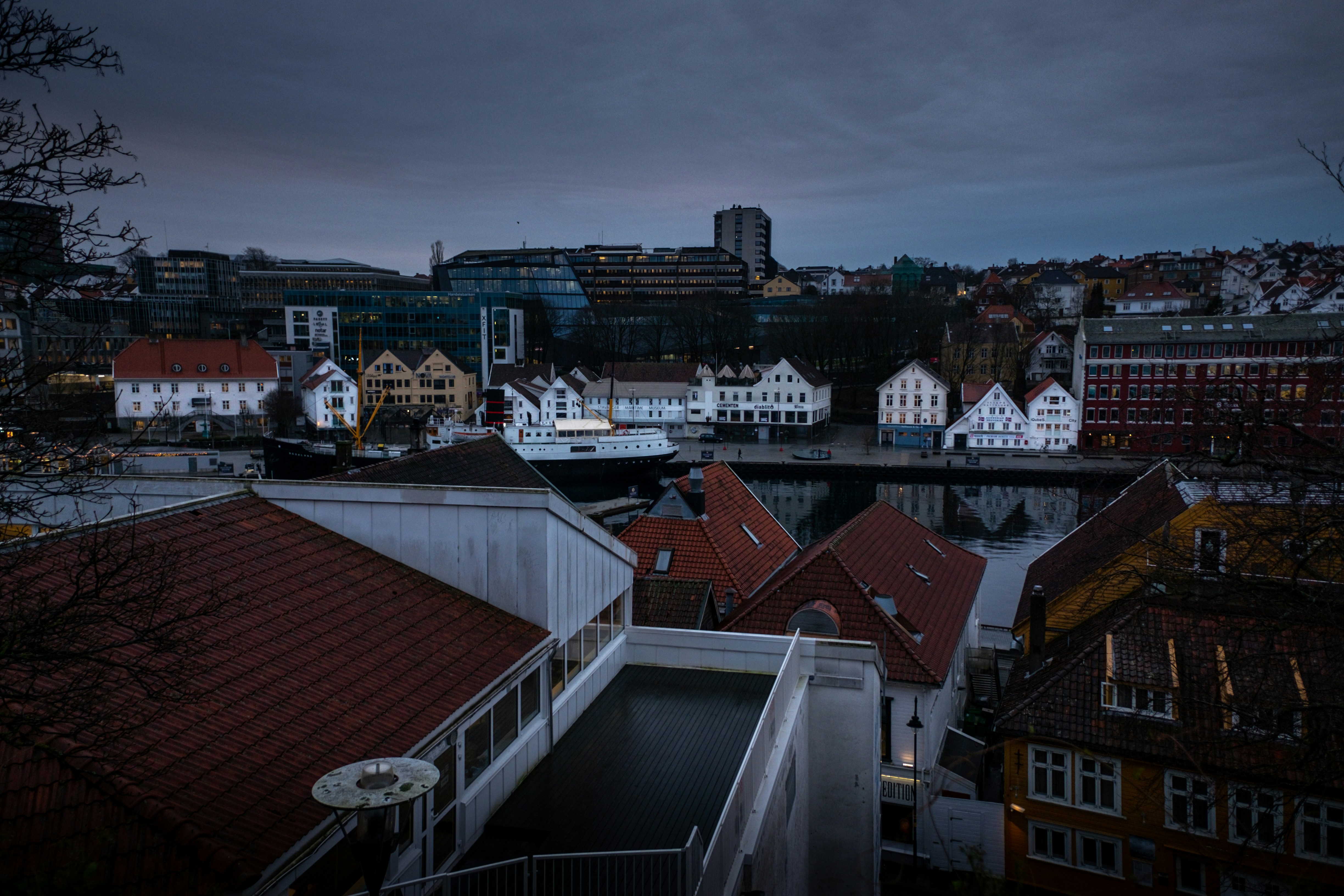 Cloudy evening view of Stavanger harbor with traditional white houses and calm waters.