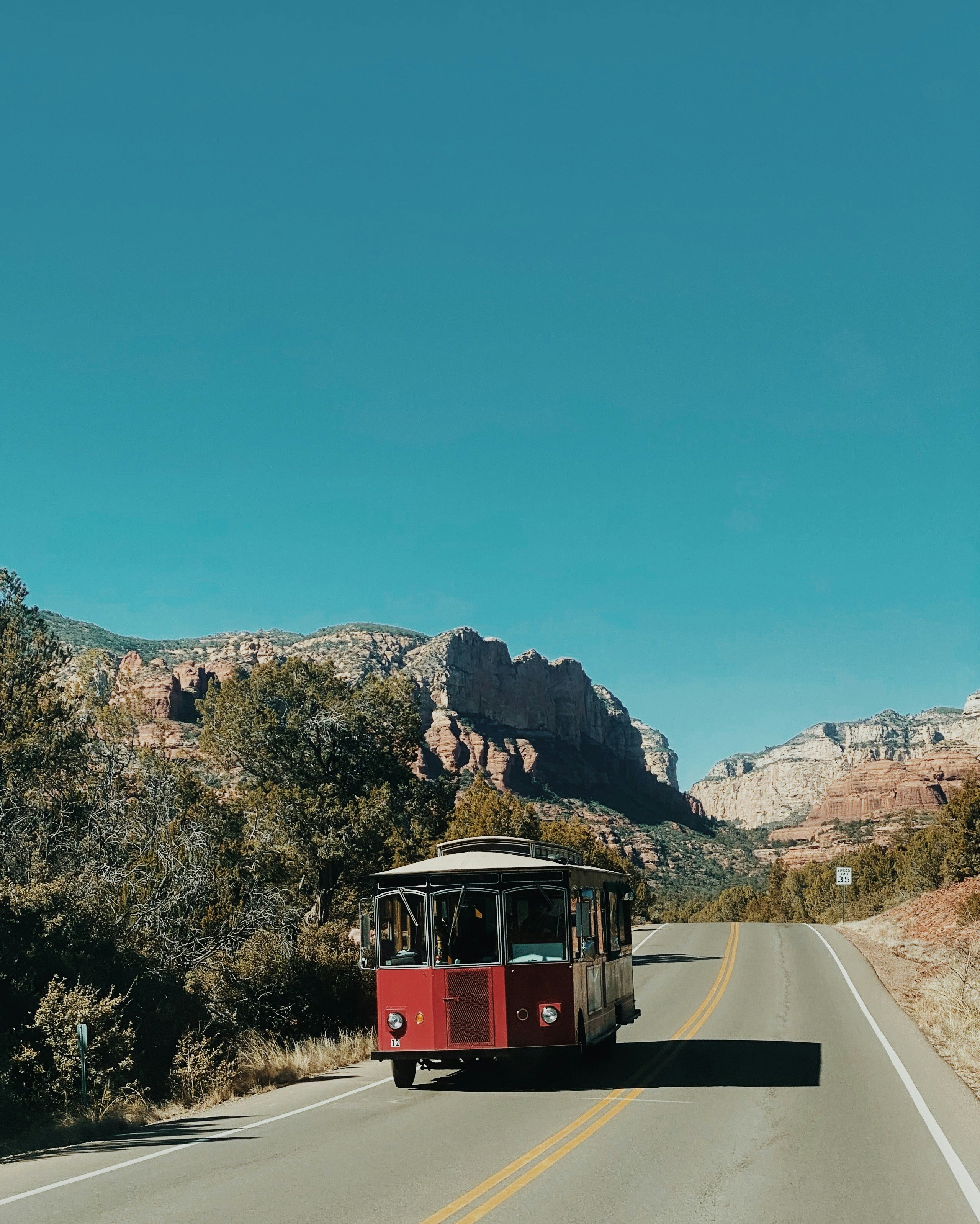 Crimson Tram Winds Through Red Canyon on a Desert Road