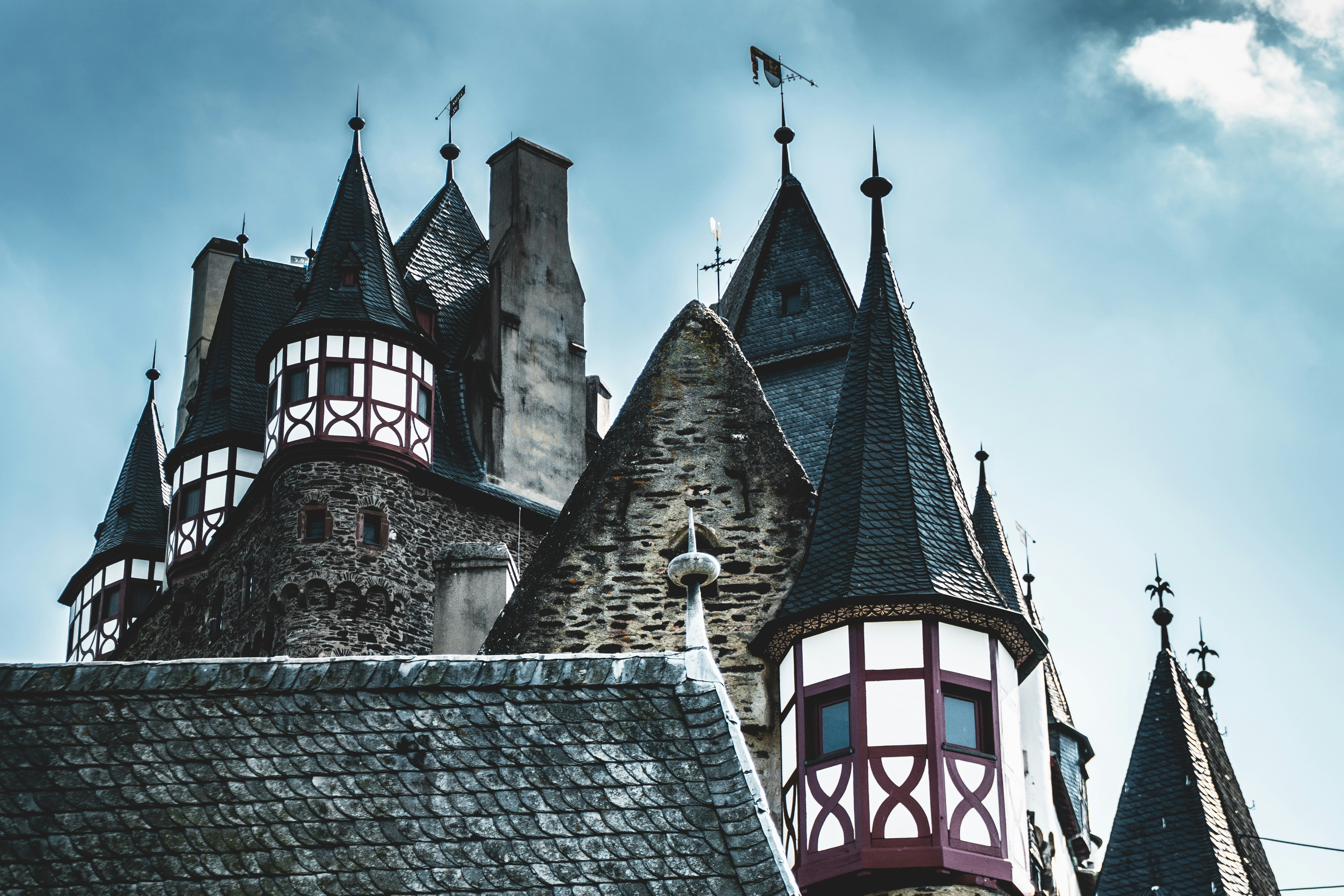 A majestic castle with intricate towers and pointed roofs under a moody sky, showcasing architectural elegance and historical charm.