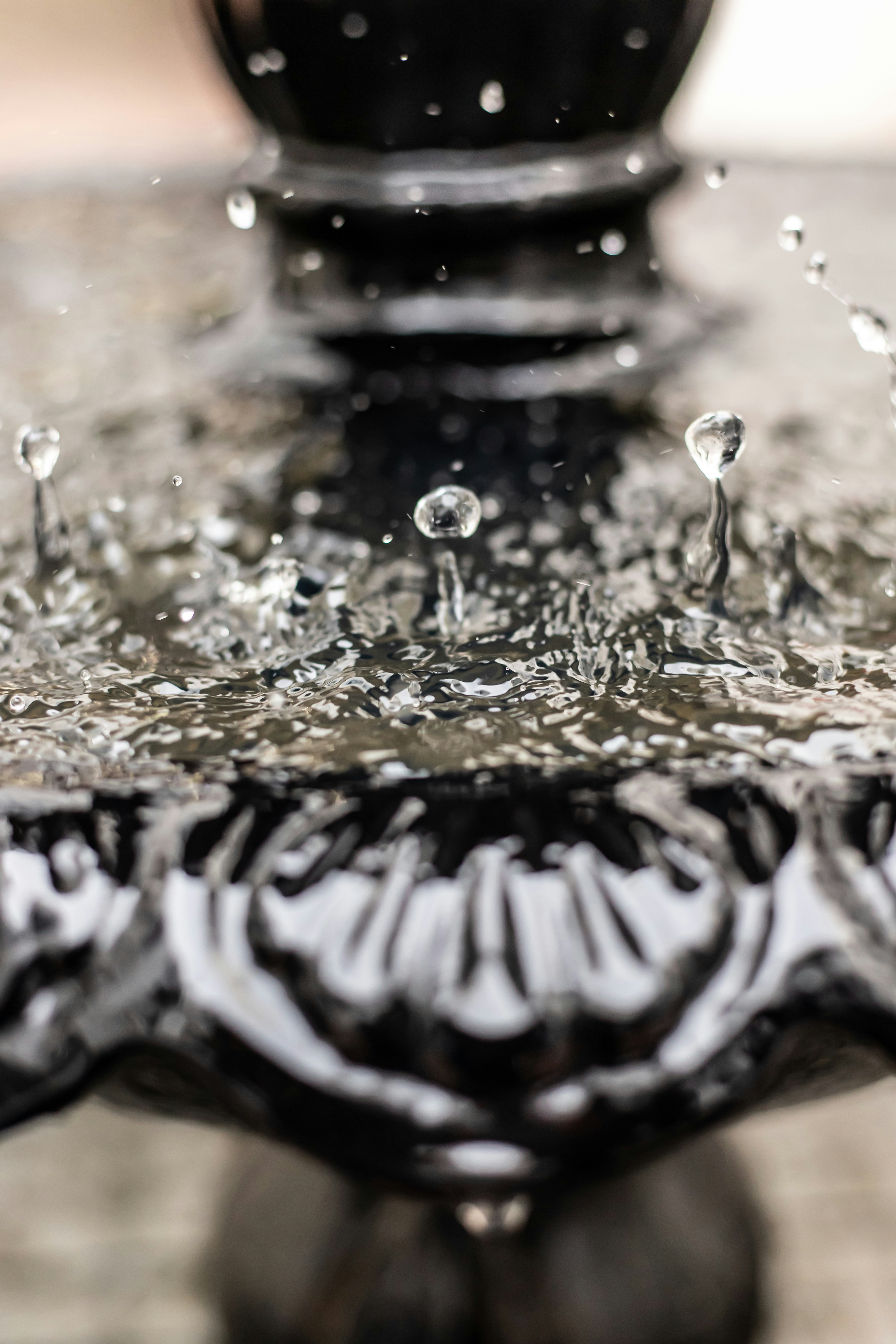 Beadfall Over Wrought-Iron: Droplets Skim the Fountain Basin