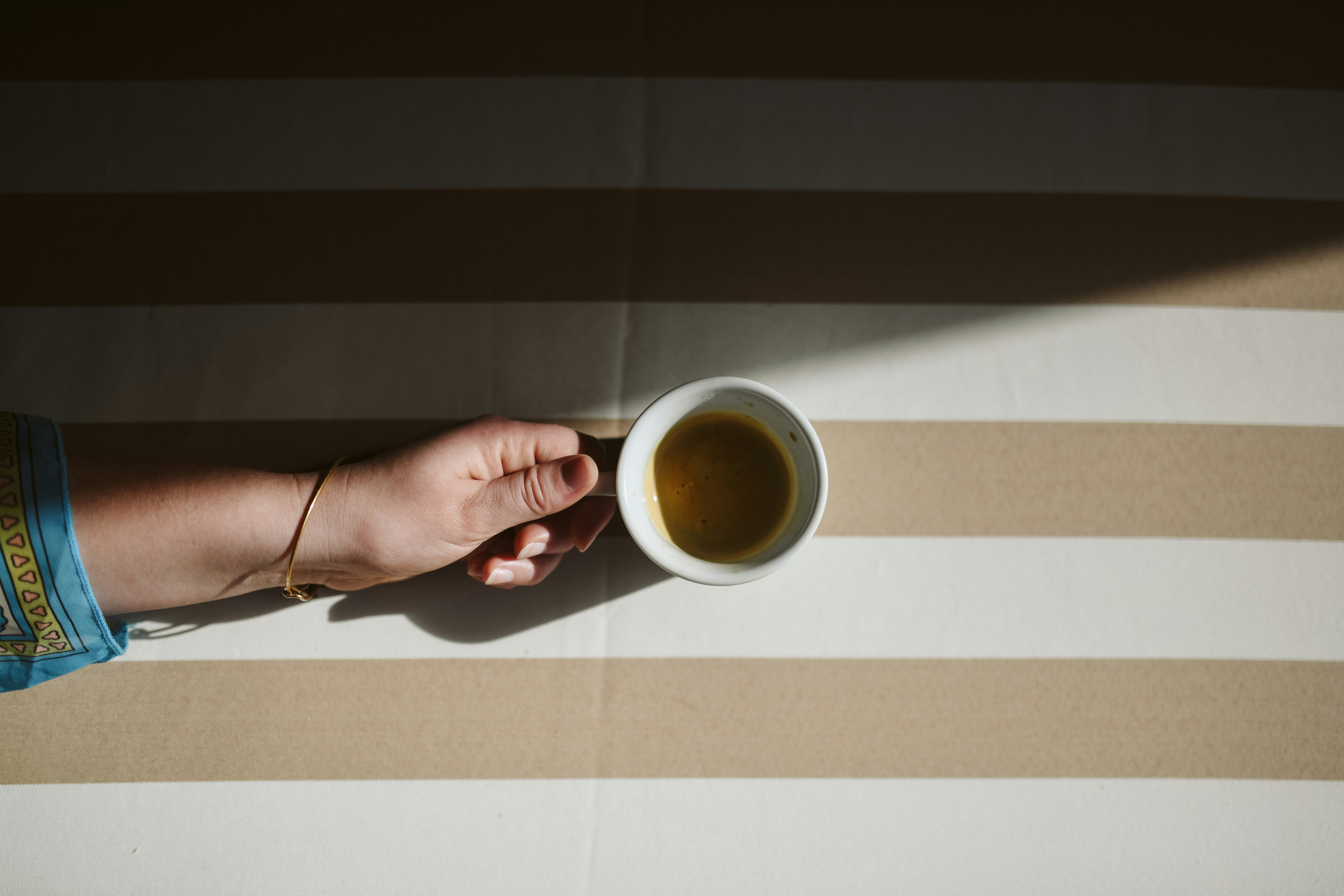 Coffee on Stripes: A Quiet Moment in Sunlit Lines