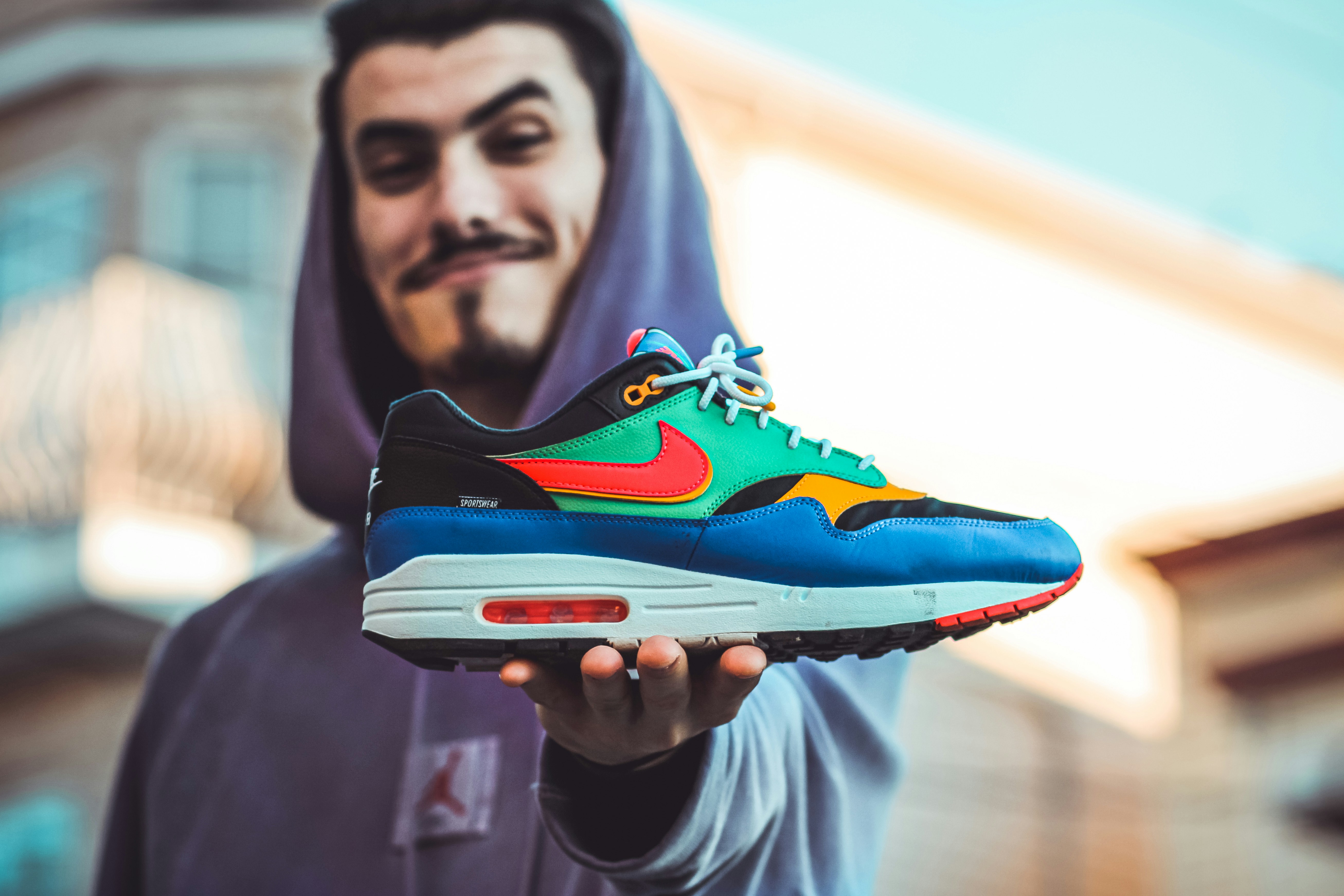 Colorful sneaker in hand: street style spotlight