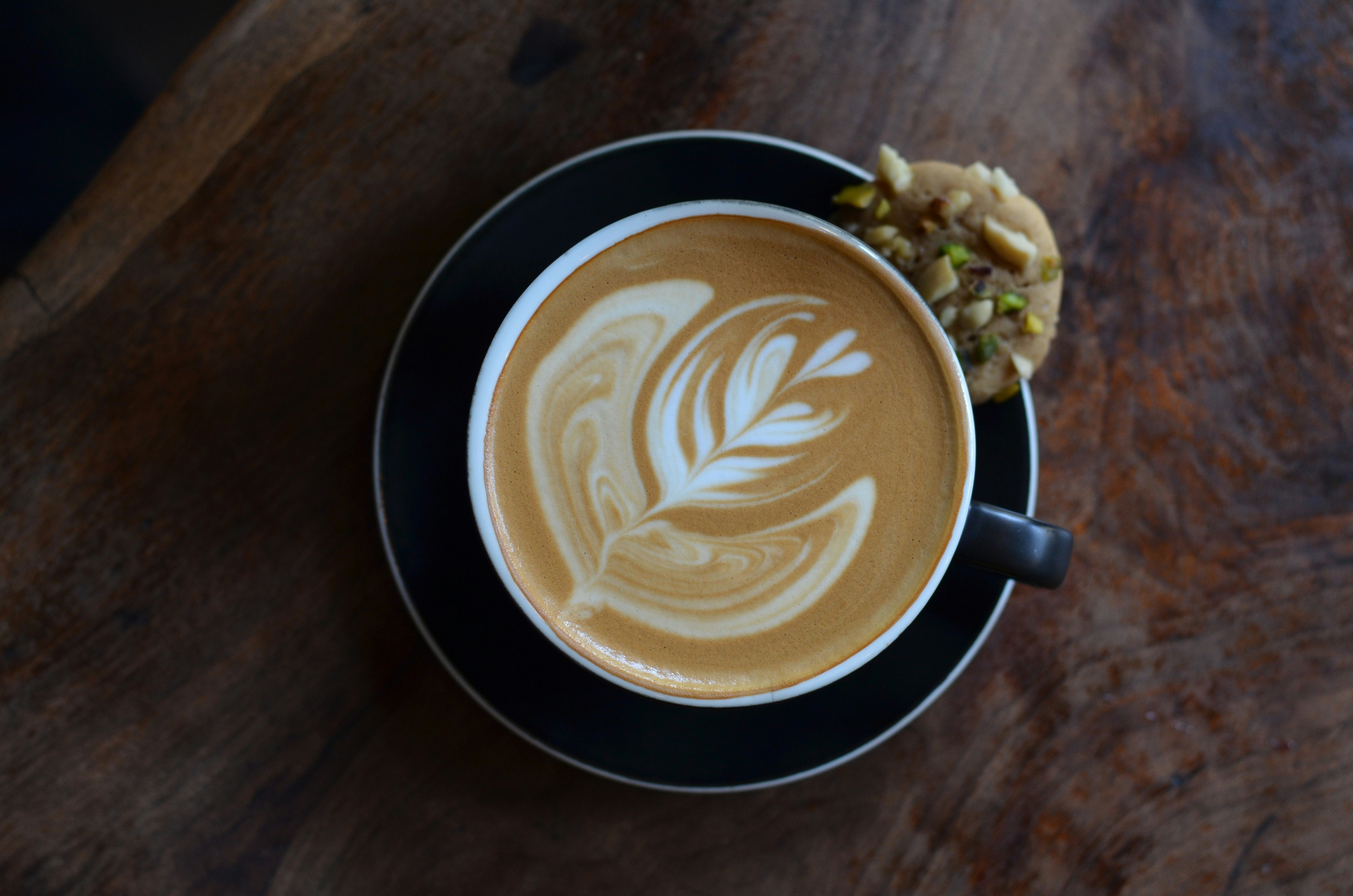 Rosette on a Dark Table: A Top-Down Latte Portrait
