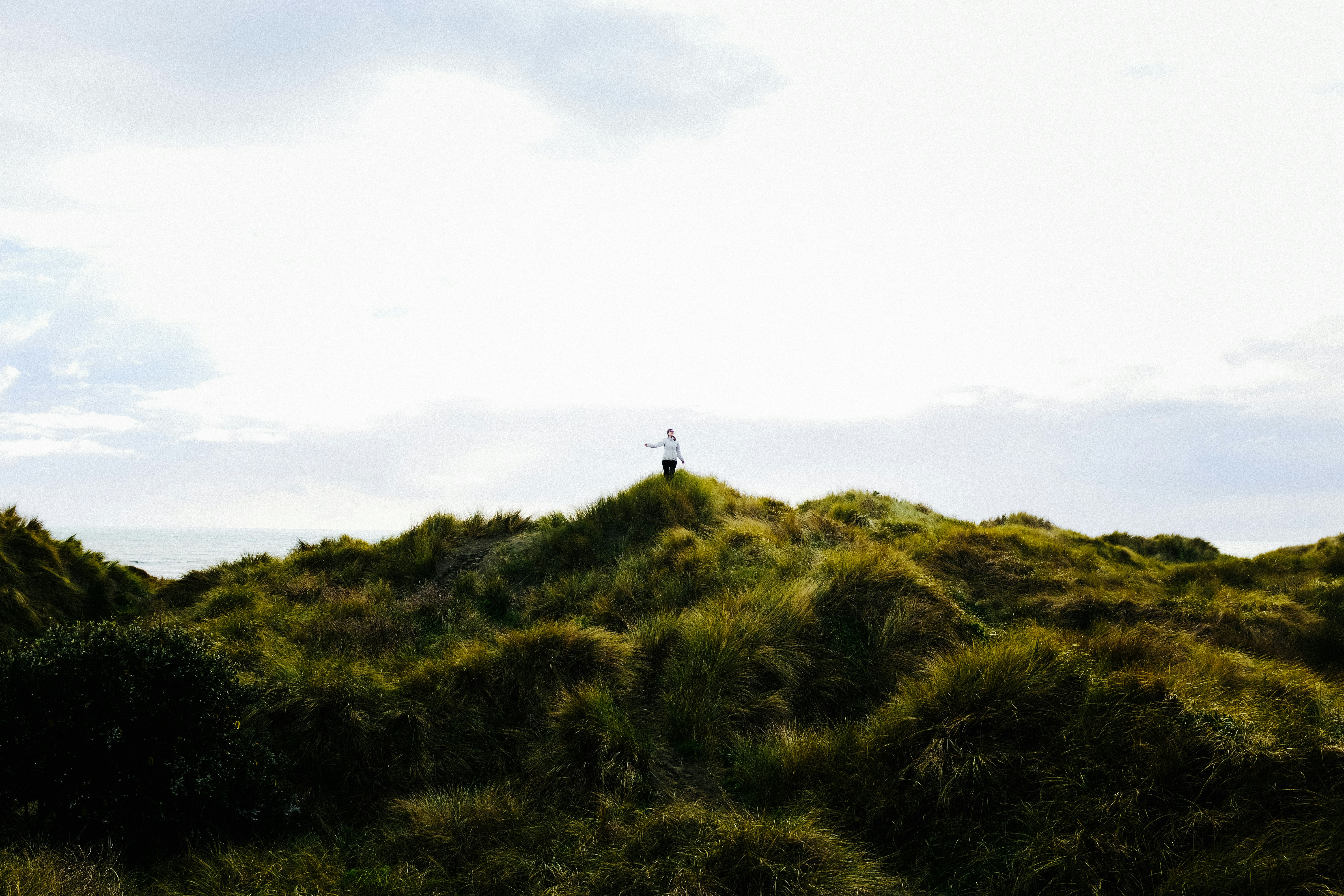 Beacon on the Crest: A Lone Lighthouse Amid Windswept Dunes