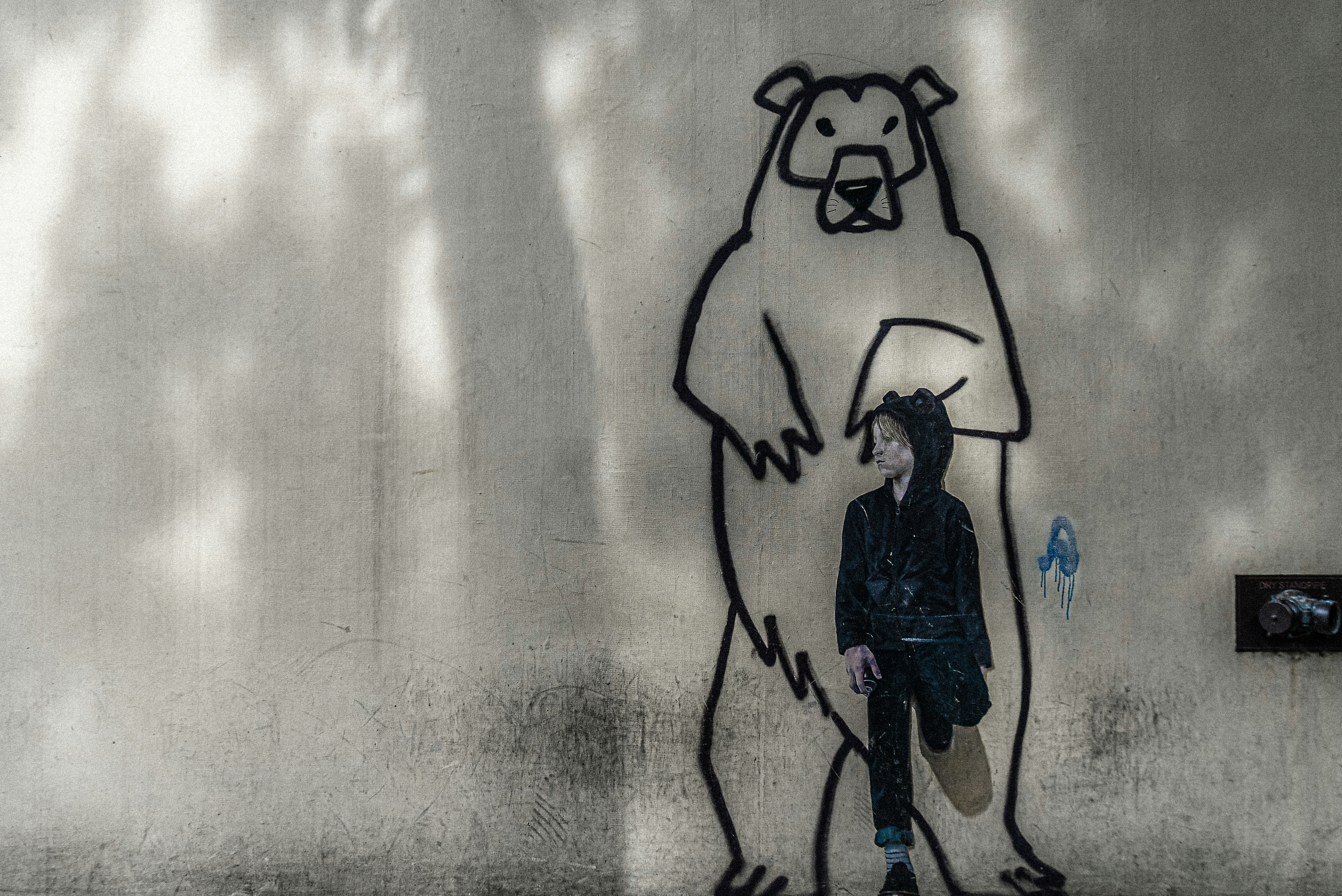 Graffiti Guardian: A Street Portrait by the Bear Wall