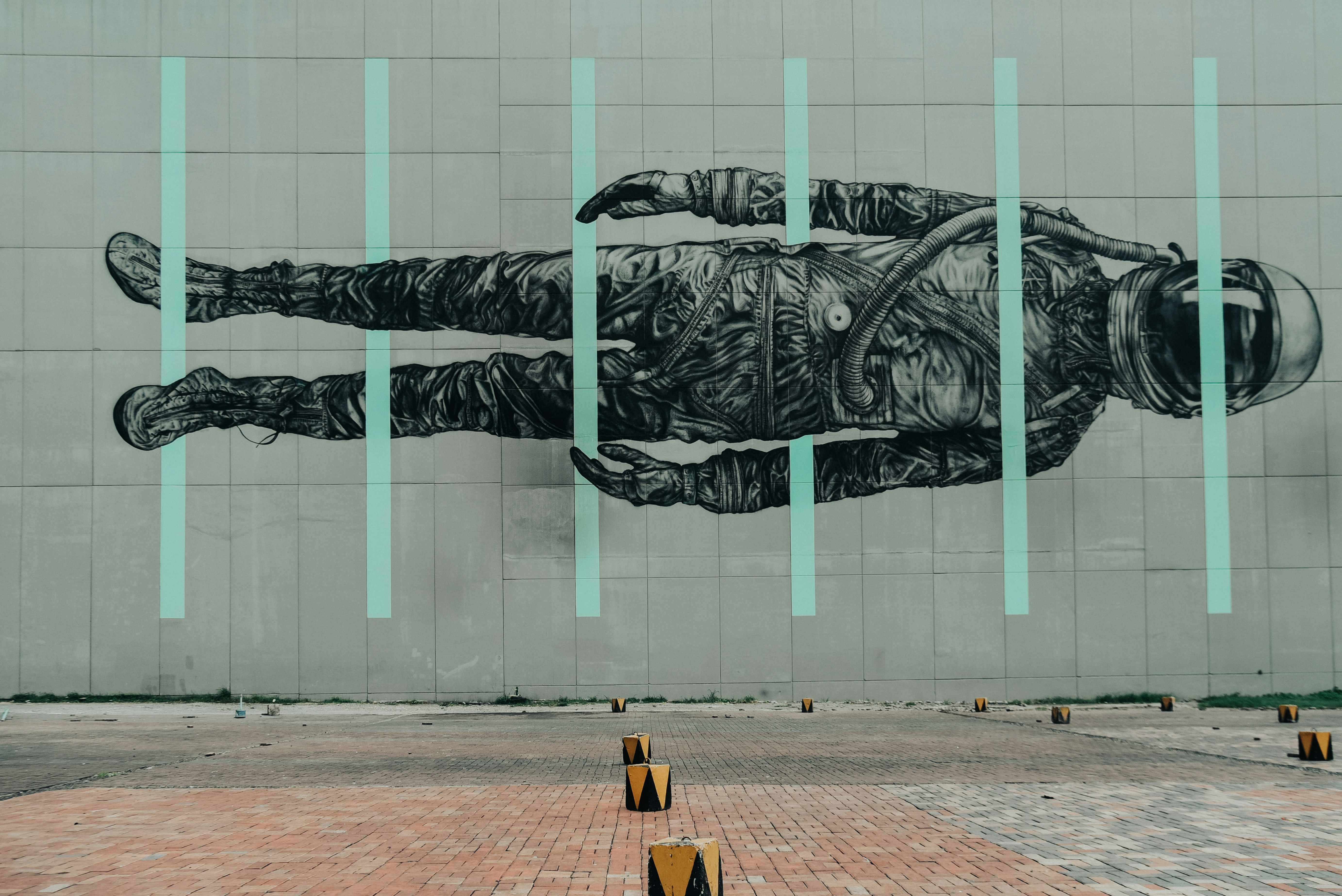 Teal-Slashed Astronaut: A Wall-Sized Mural Across a Brick Plaza