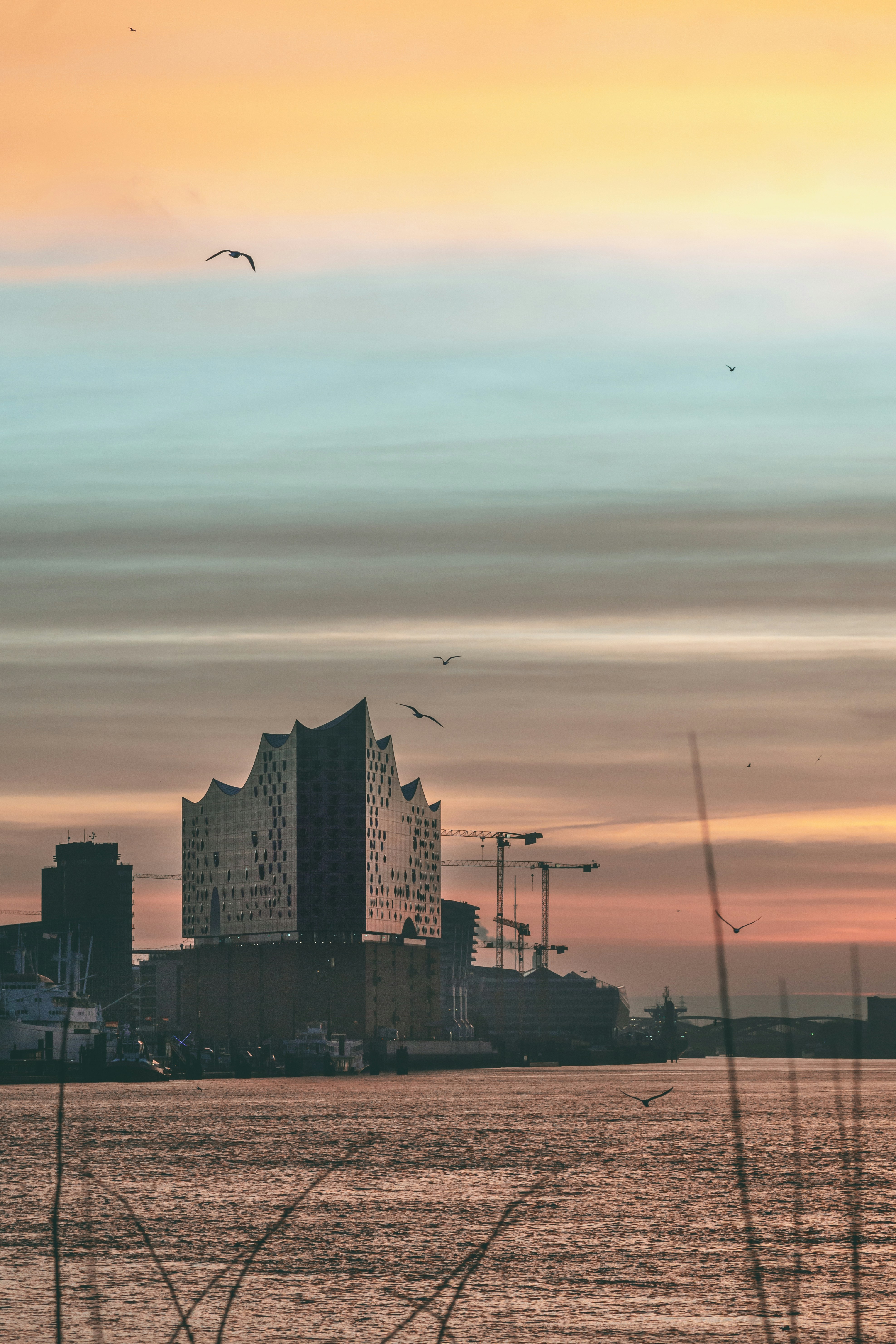 Sunset Over the Modern Pier: Waves, Shadows, and a Faceted Skyline