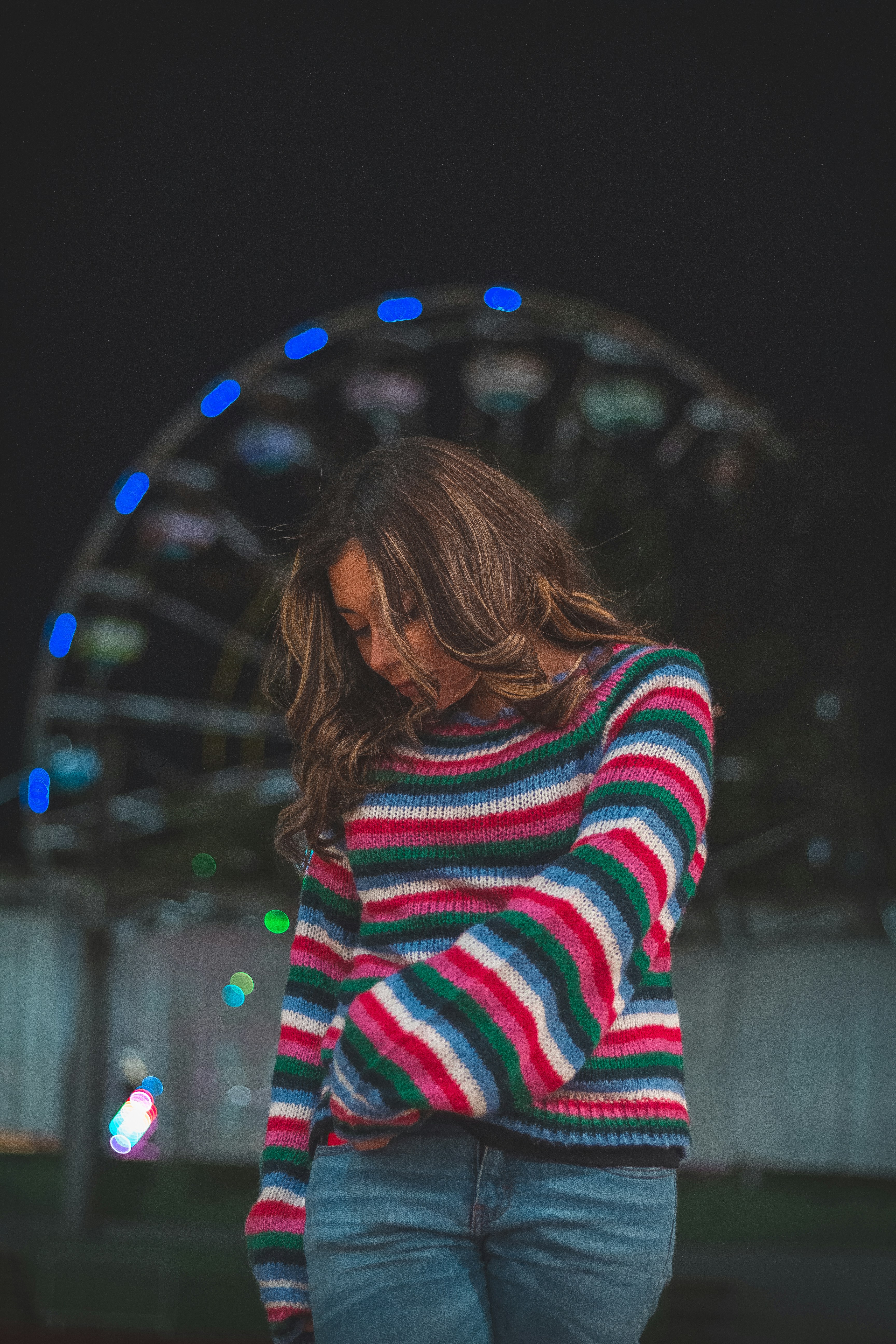 Stripes Under Neon Arcs: A Quiet Moment by the Ferris Wheel