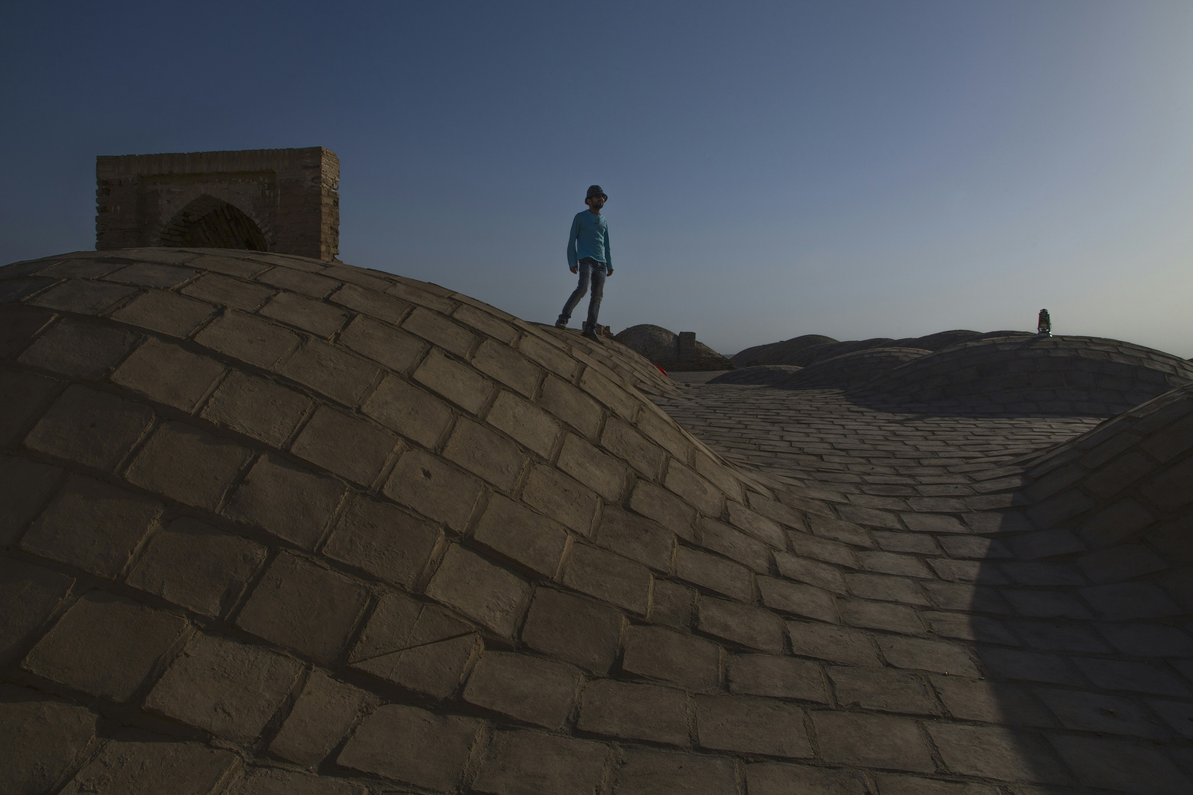 Blue-Jacket Figure Amid Desert Tiles at Dusk