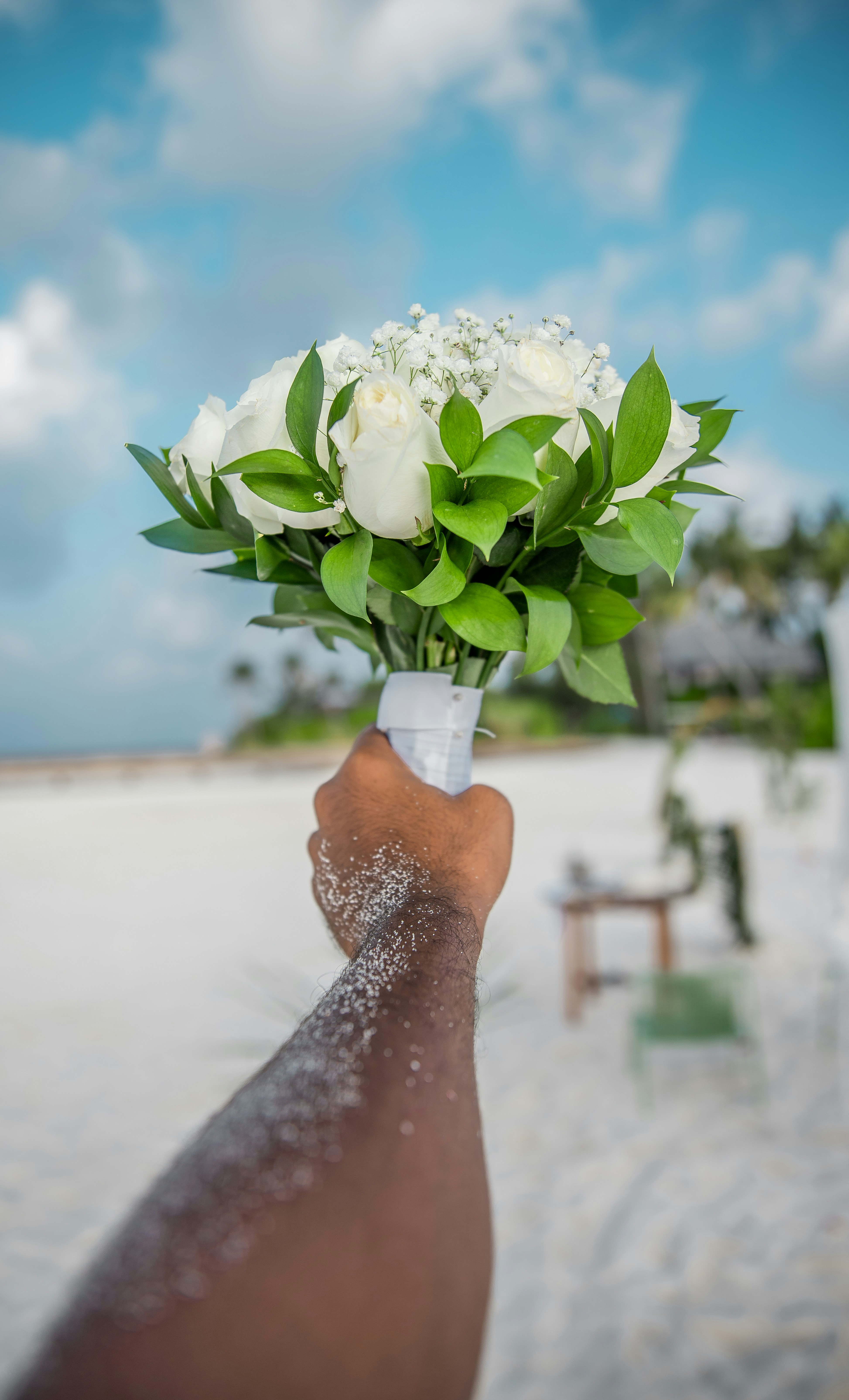 person holding white flower bouquet