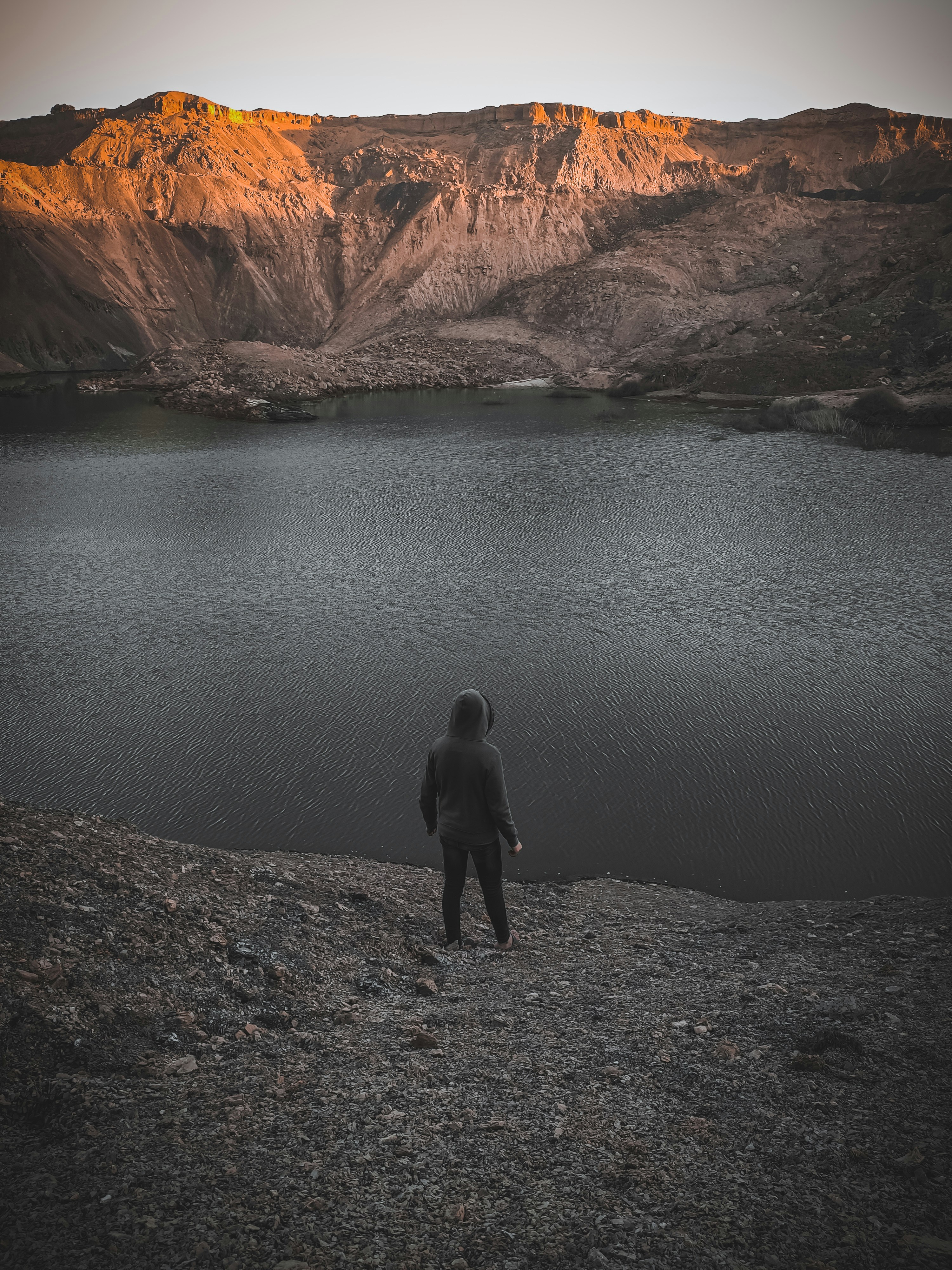 2 personnes debout sur un sol rocheux près du lac pendant la journée ...