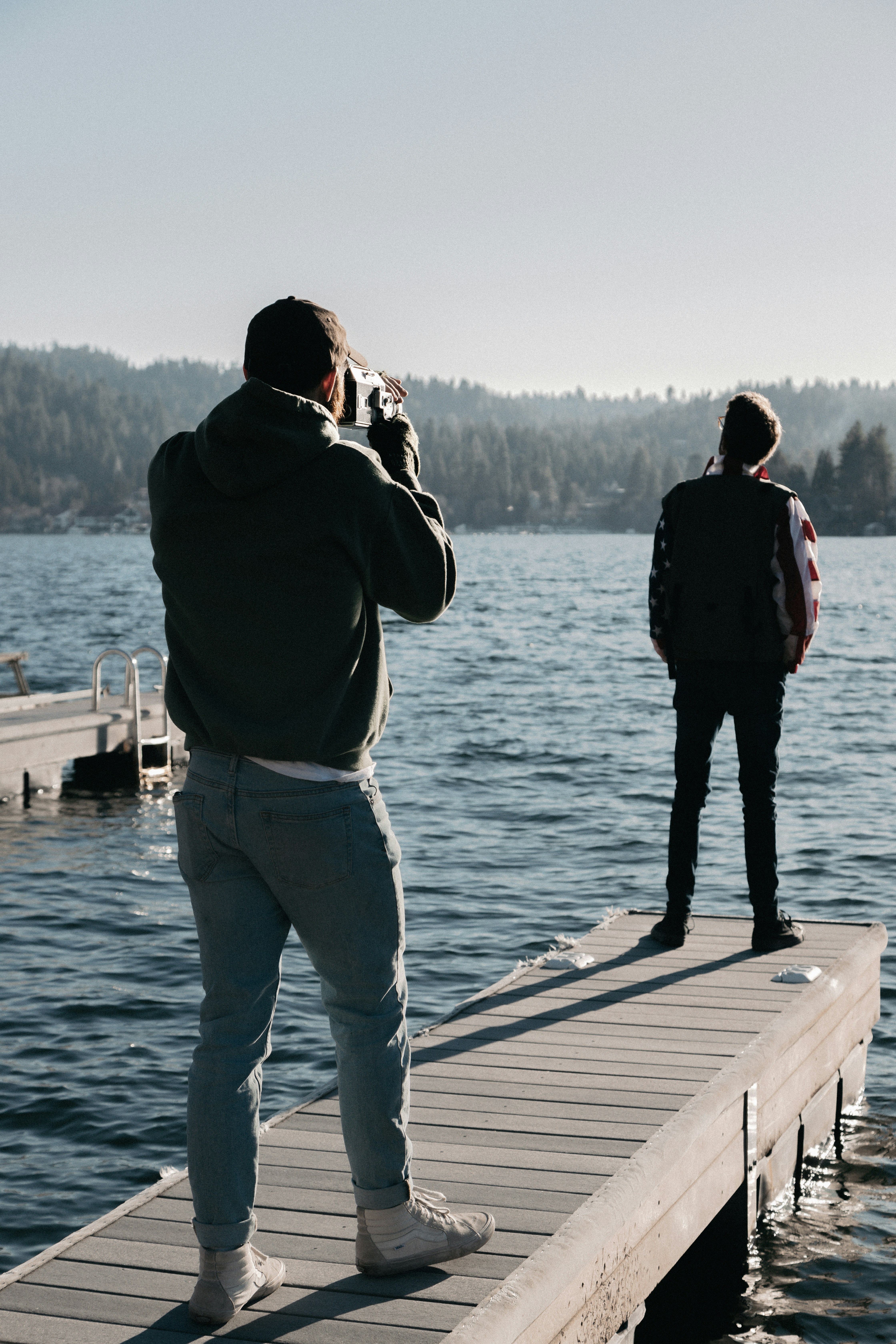 Standby by the Lake: Capturing a Photographer and a Contemplative Figure at Dusk