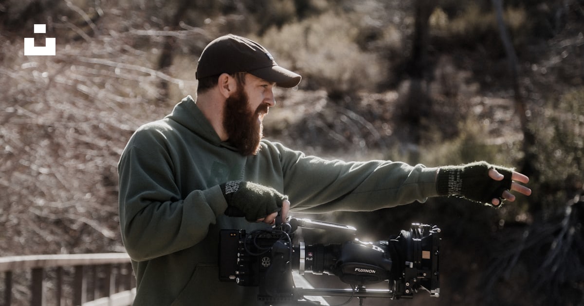 Foto Hombre Con Chaqueta Verde Sosteniendo Una Cámara Dslr Negra