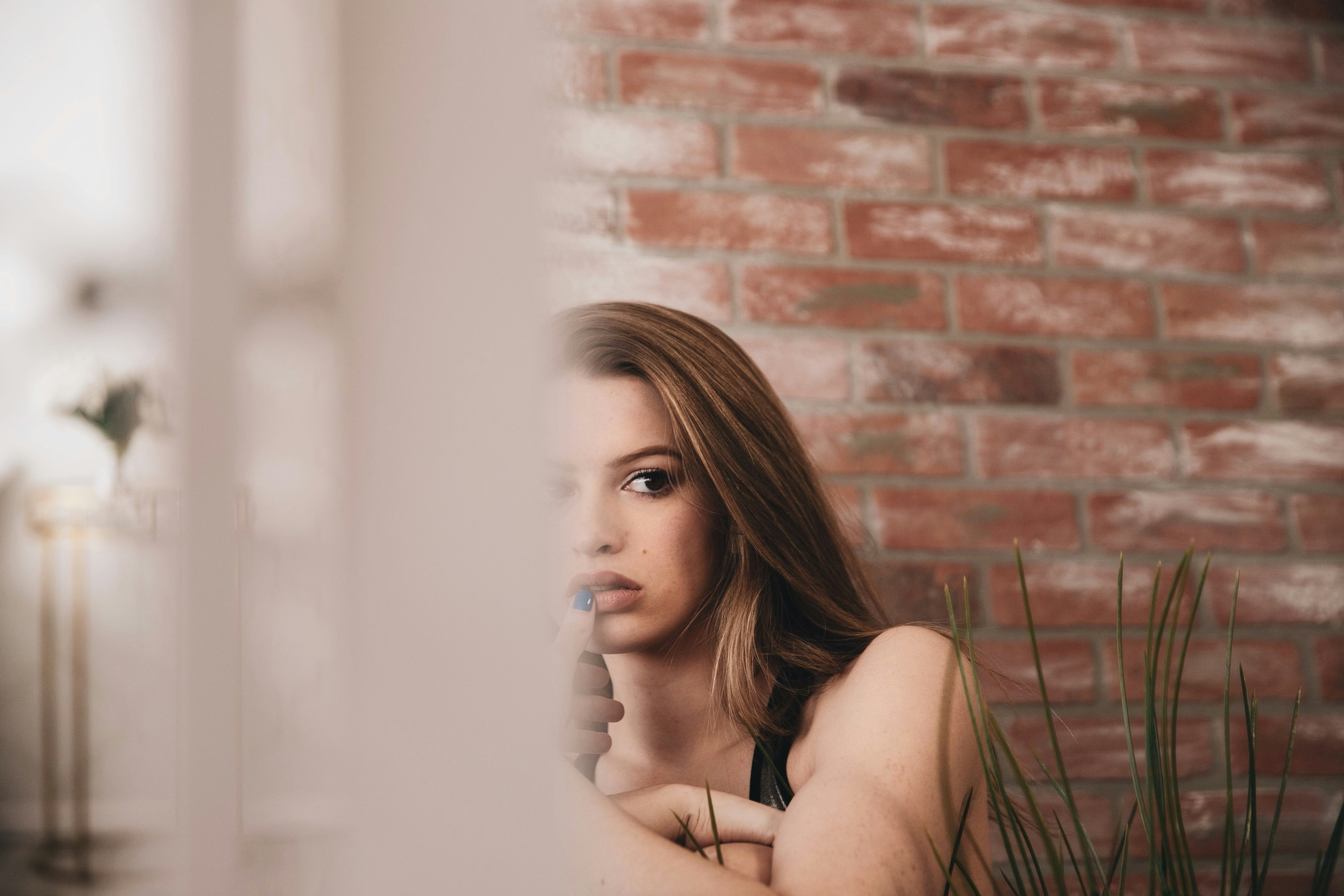 Woman in black tank top leaning on brown brick wall photo – Free ...